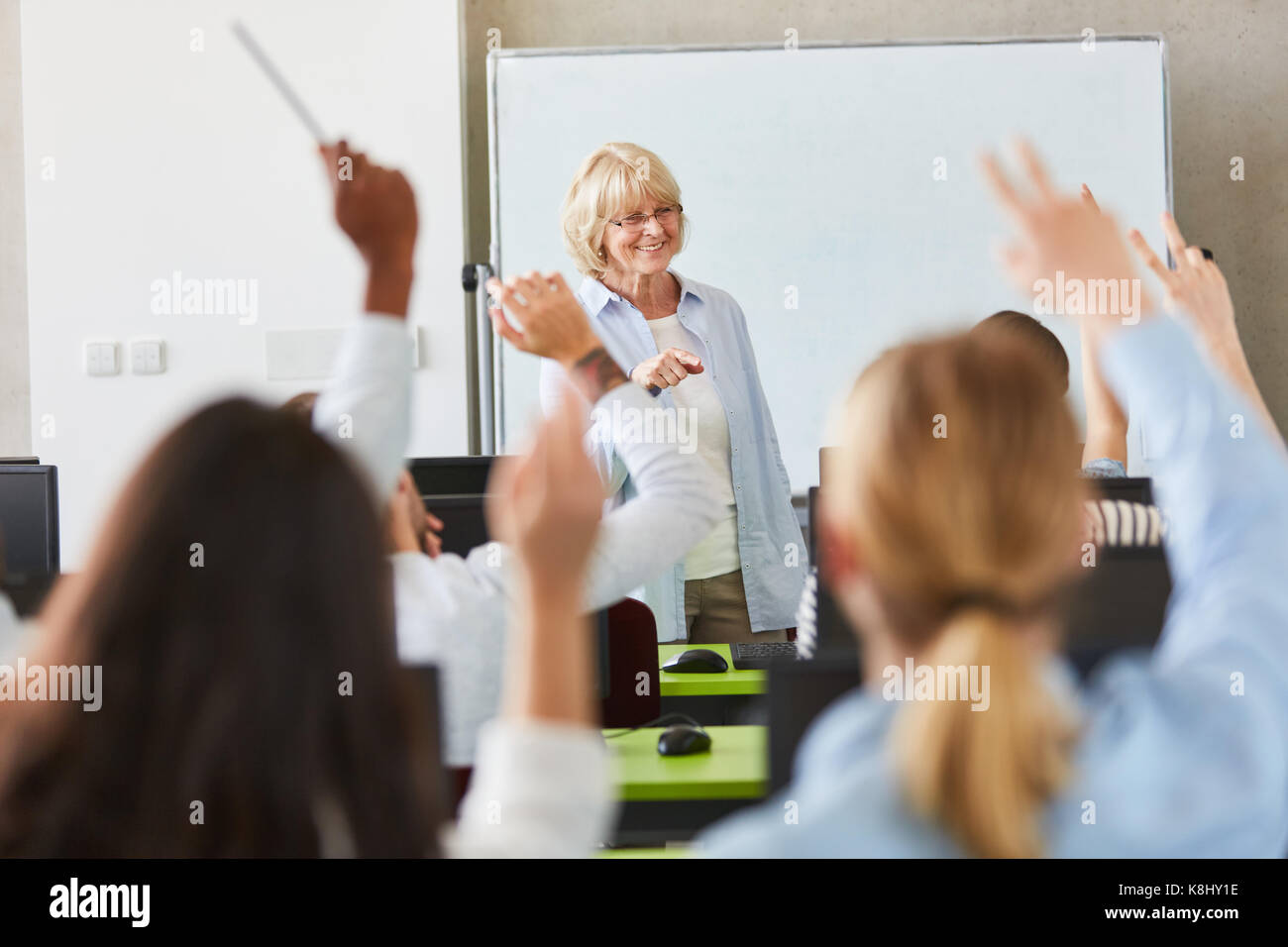 Many students in school lessons raising hands Stock Photo - Alamy