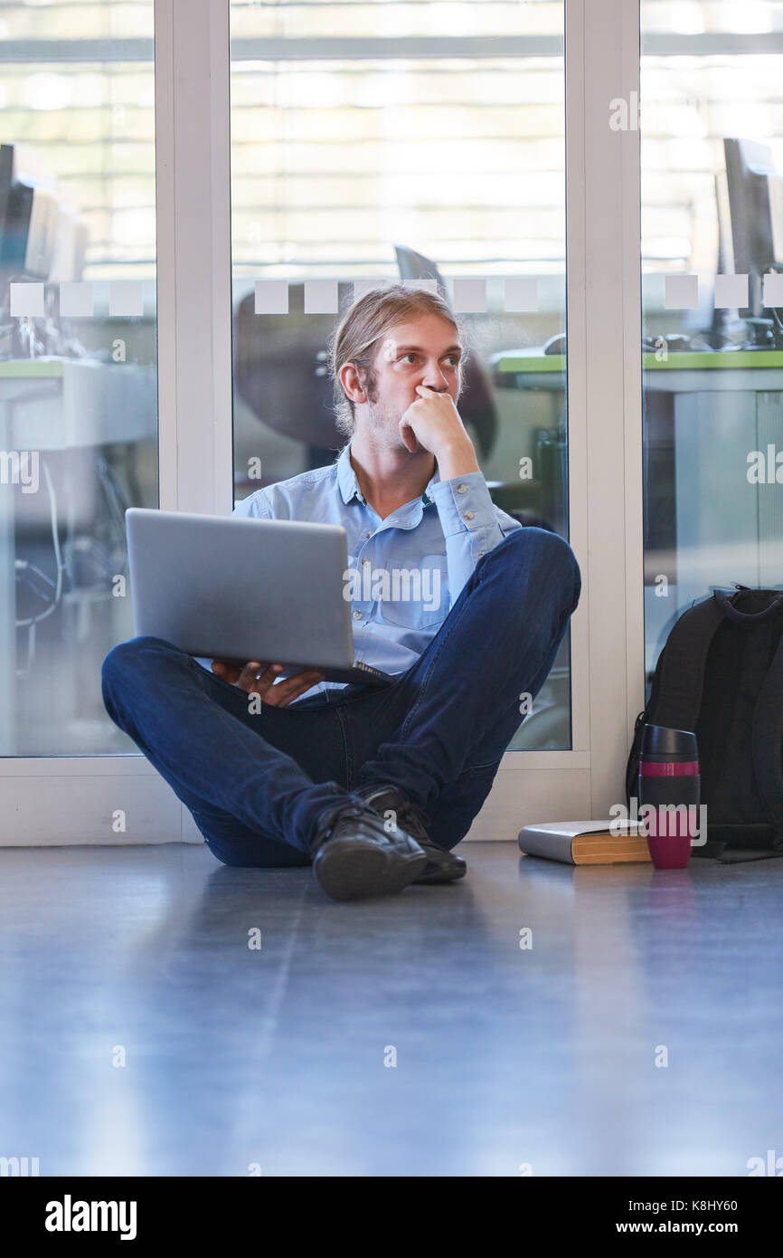 Student with laptop think about problem in university Stock Photo - Alamy