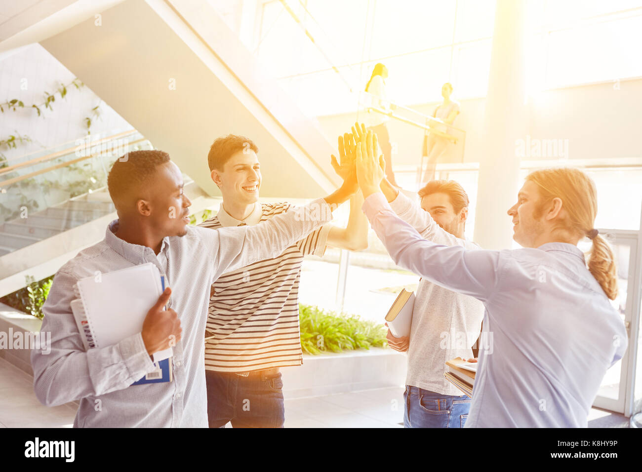 Group of students gives High Five in university as a team Stock Photo ...