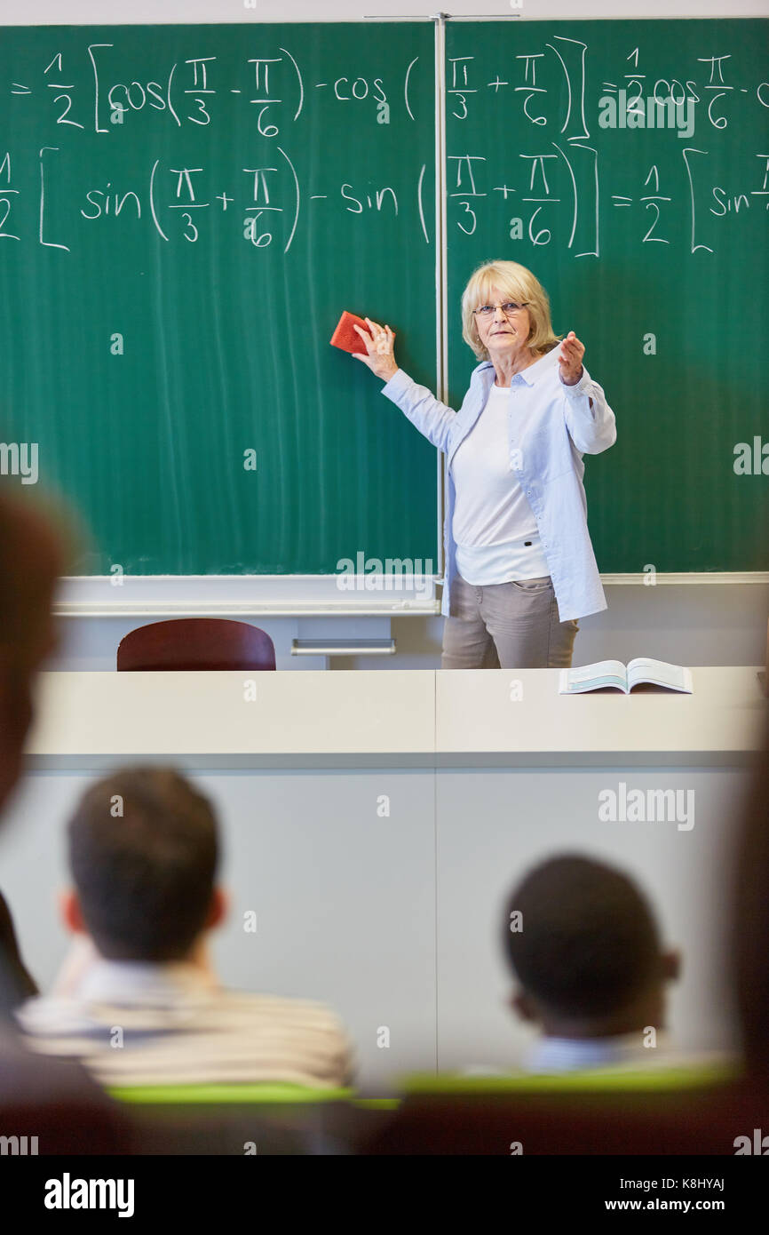 Woman as math teacher in university with chalkboard Stock Photo - Alamy
