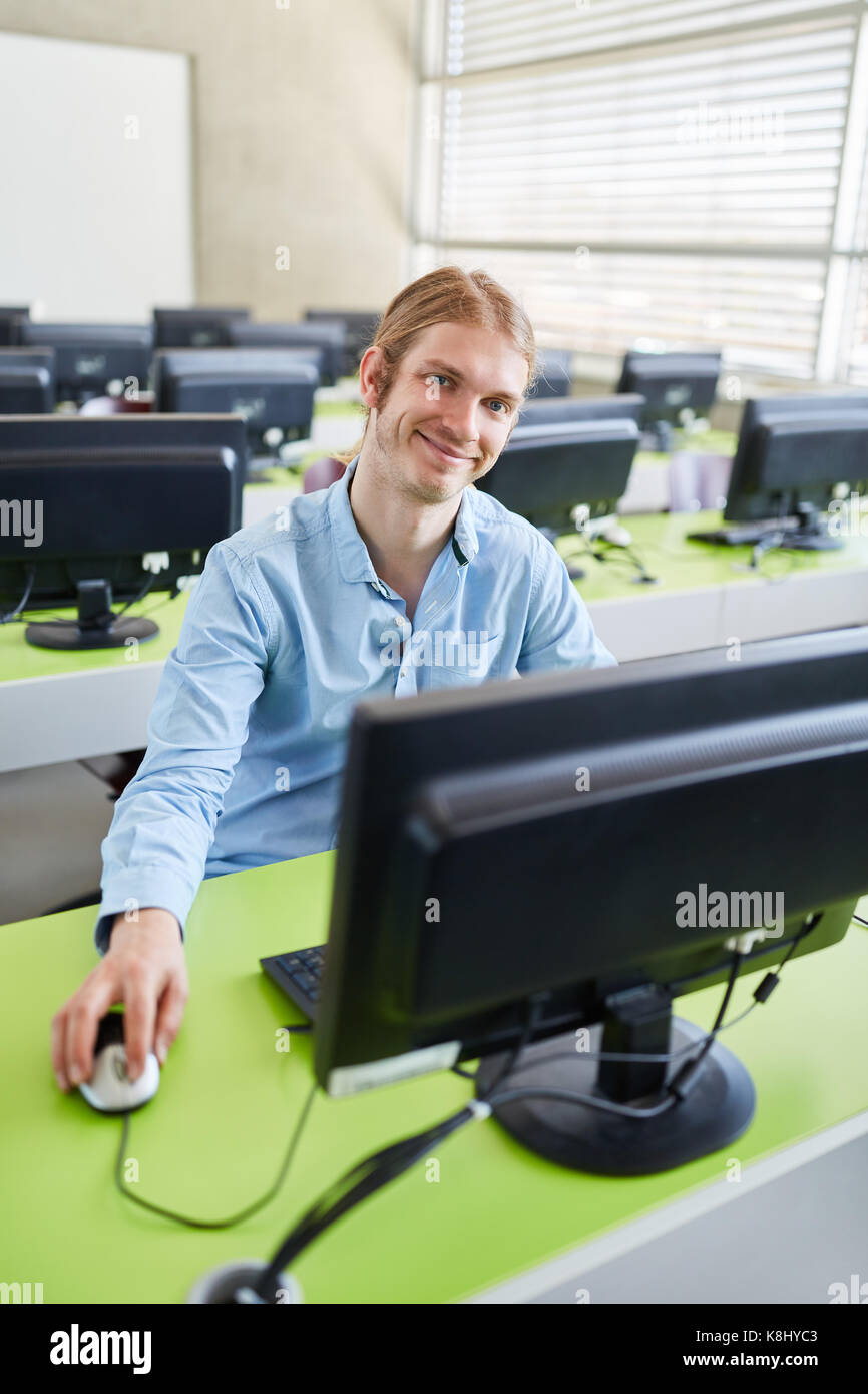 Man as IT student sitting with computer in university Stock Photo - Alamy