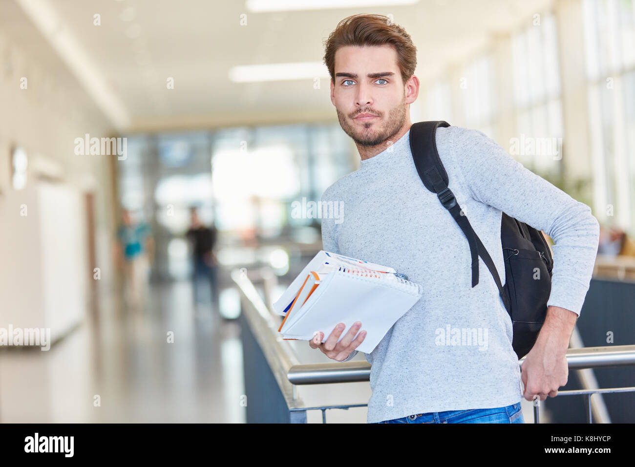 Young man as student or pupil in university holding his books Stock ...