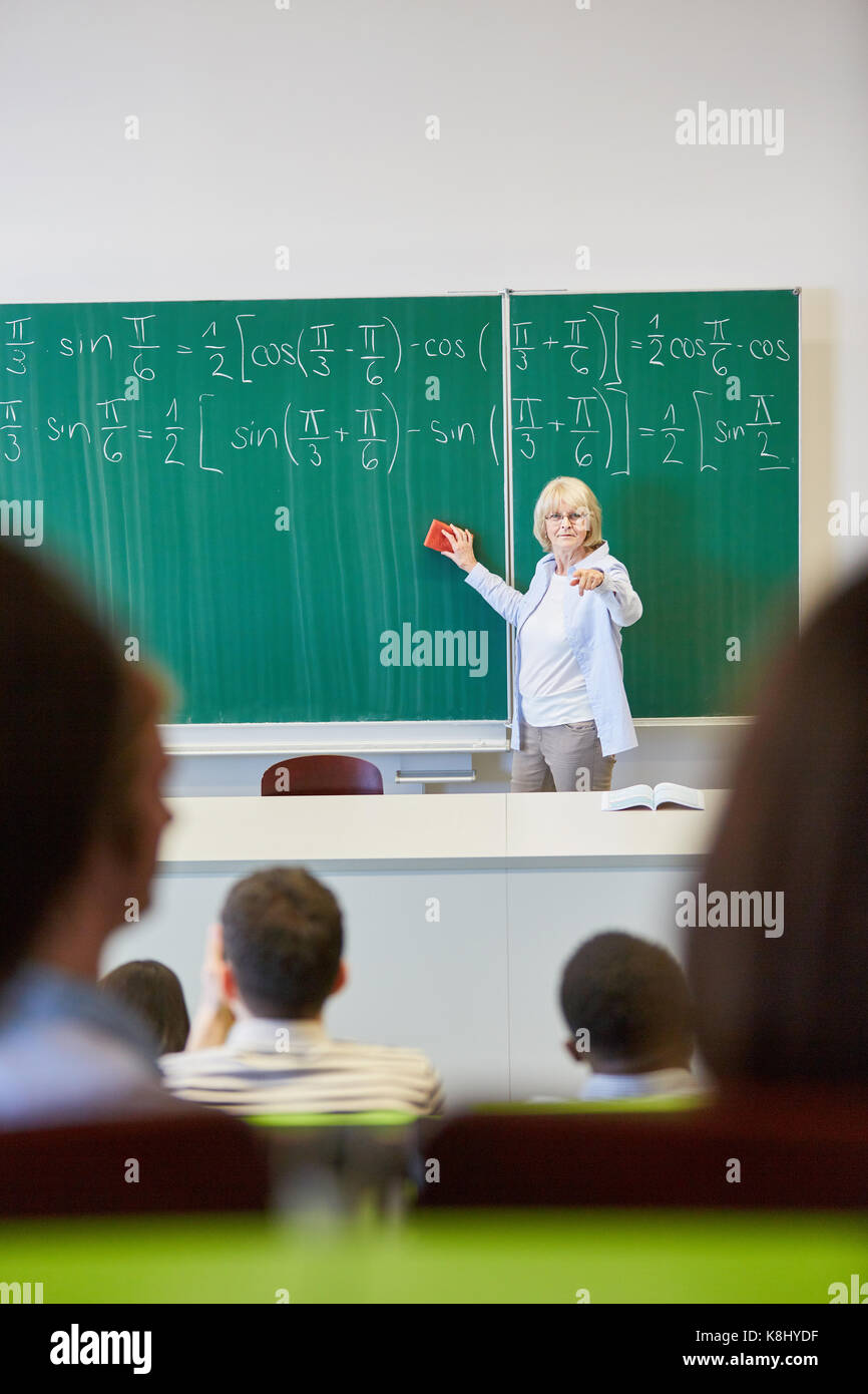 Woman as teacher in math class using chalkboard for lecture Stock Photo ...