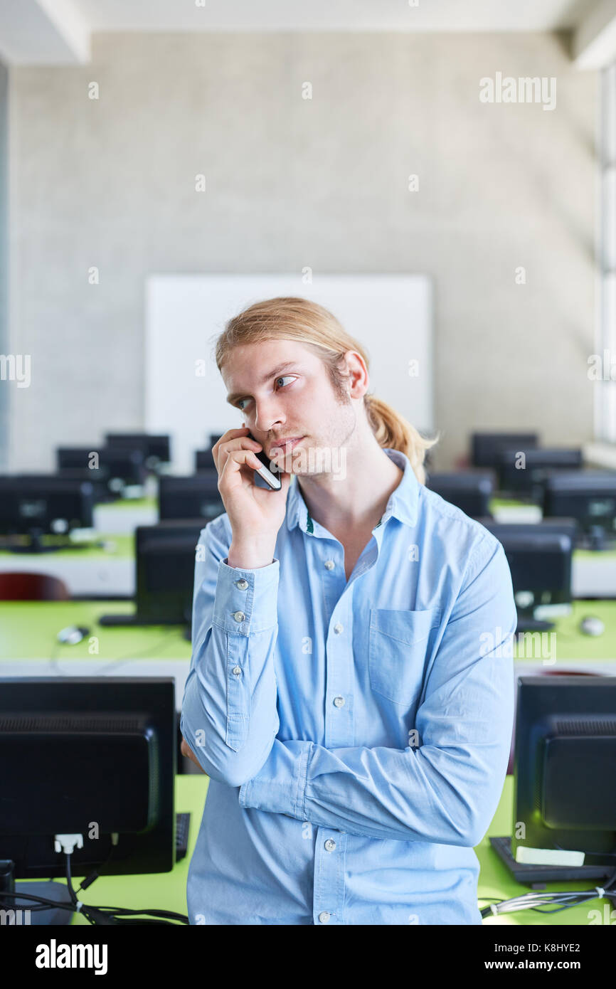 Student making call with smartphone in university Stock Photo - Alamy