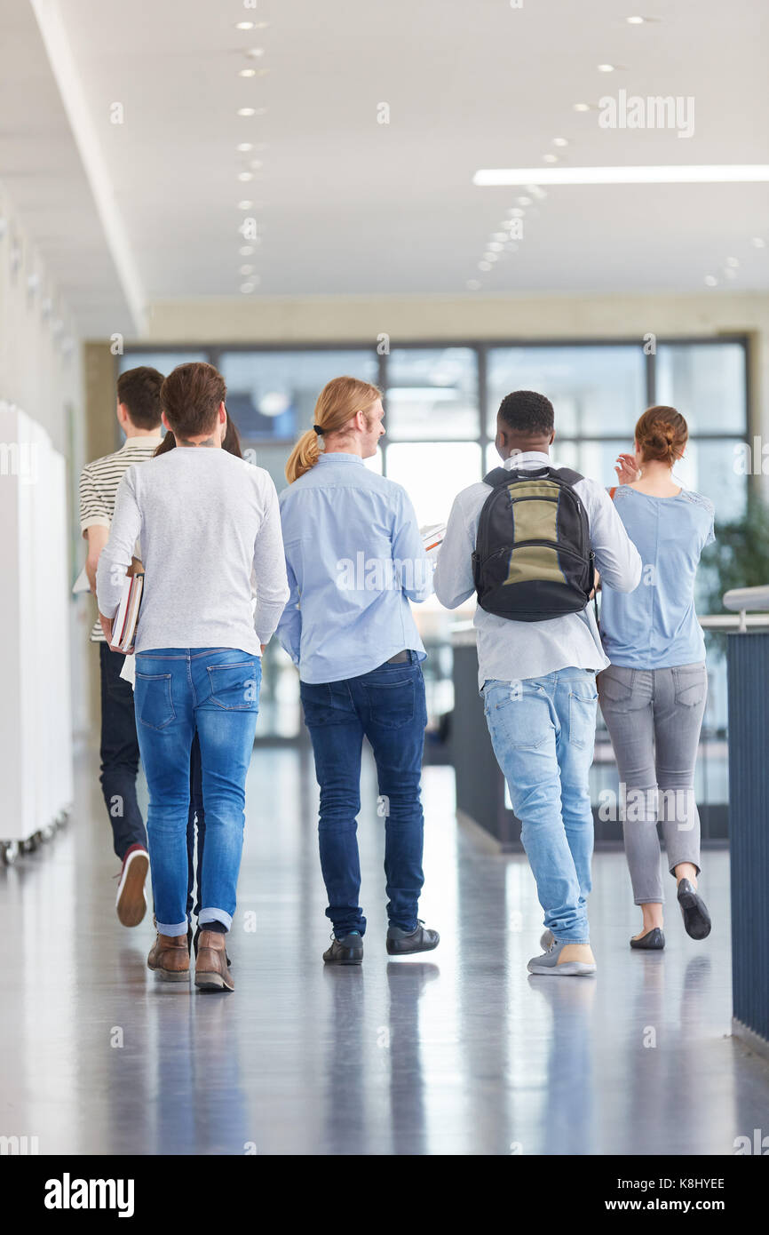 Group of students in the uni walk in hallway Stock Photo - Alamy