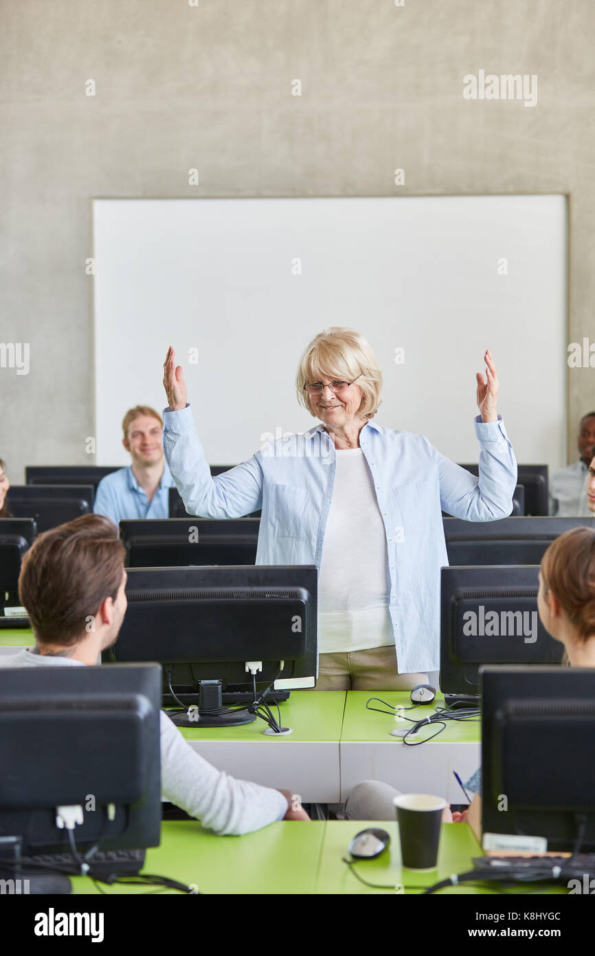 Woman as university teacher in computer course with students Stock ...