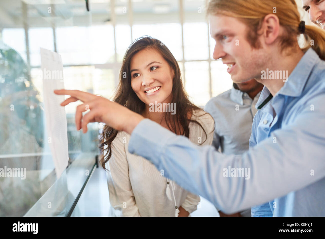 Students check test grades in university hallway Stock Photo - Alamy