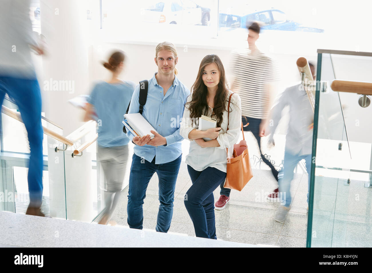Young couple as freshmen in uni at busy staircase Stock Photo - Alamy