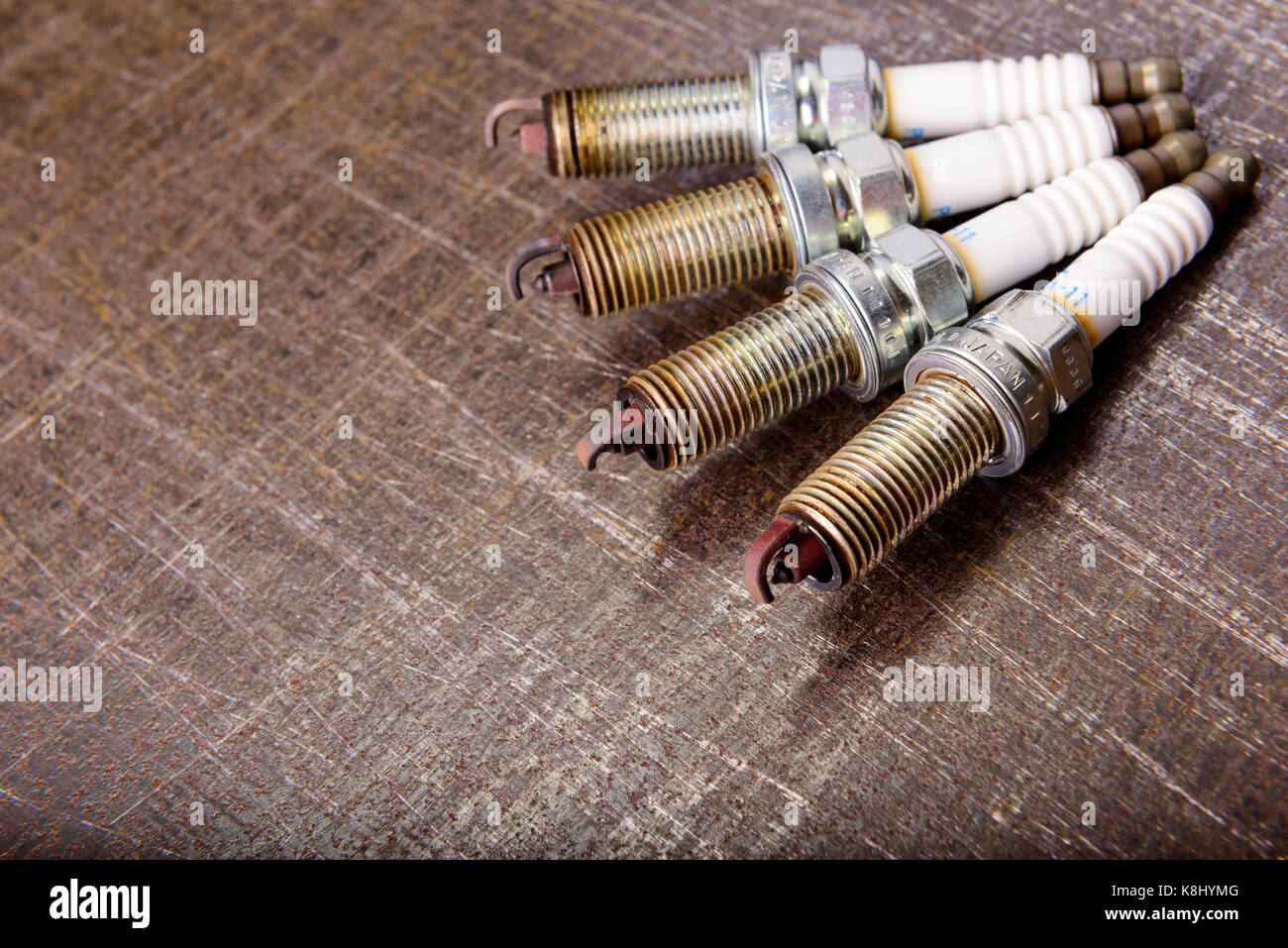 composition of four spark plugs on a metal background Stock Photo - Alamy