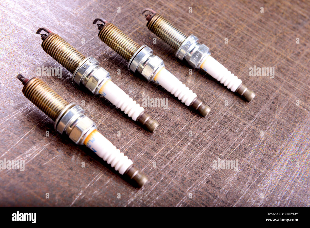 composition of four spark plugs on a metal background Stock Photo - Alamy