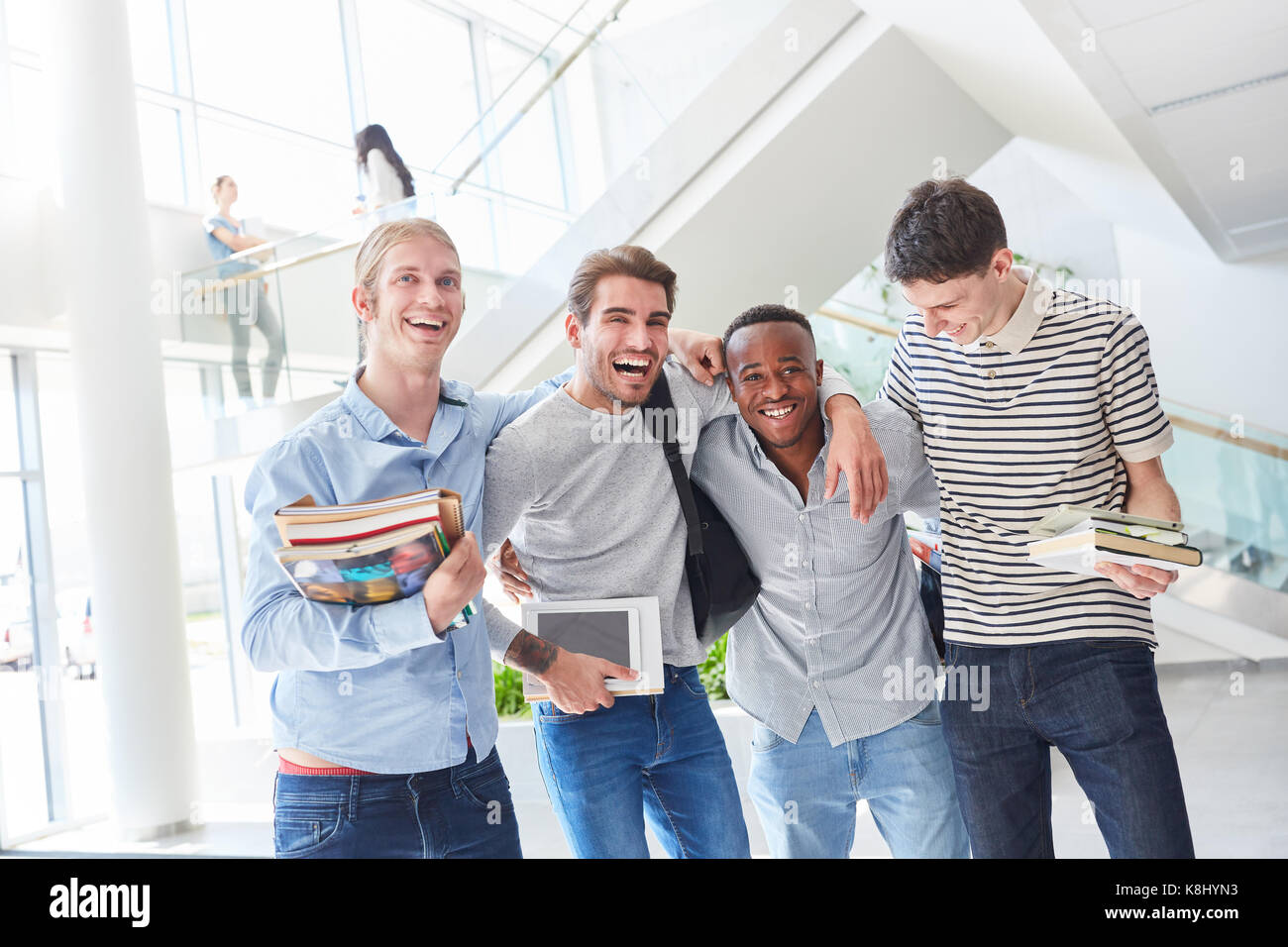Happy friends and students team in uni laughing Stock Photo - Alamy