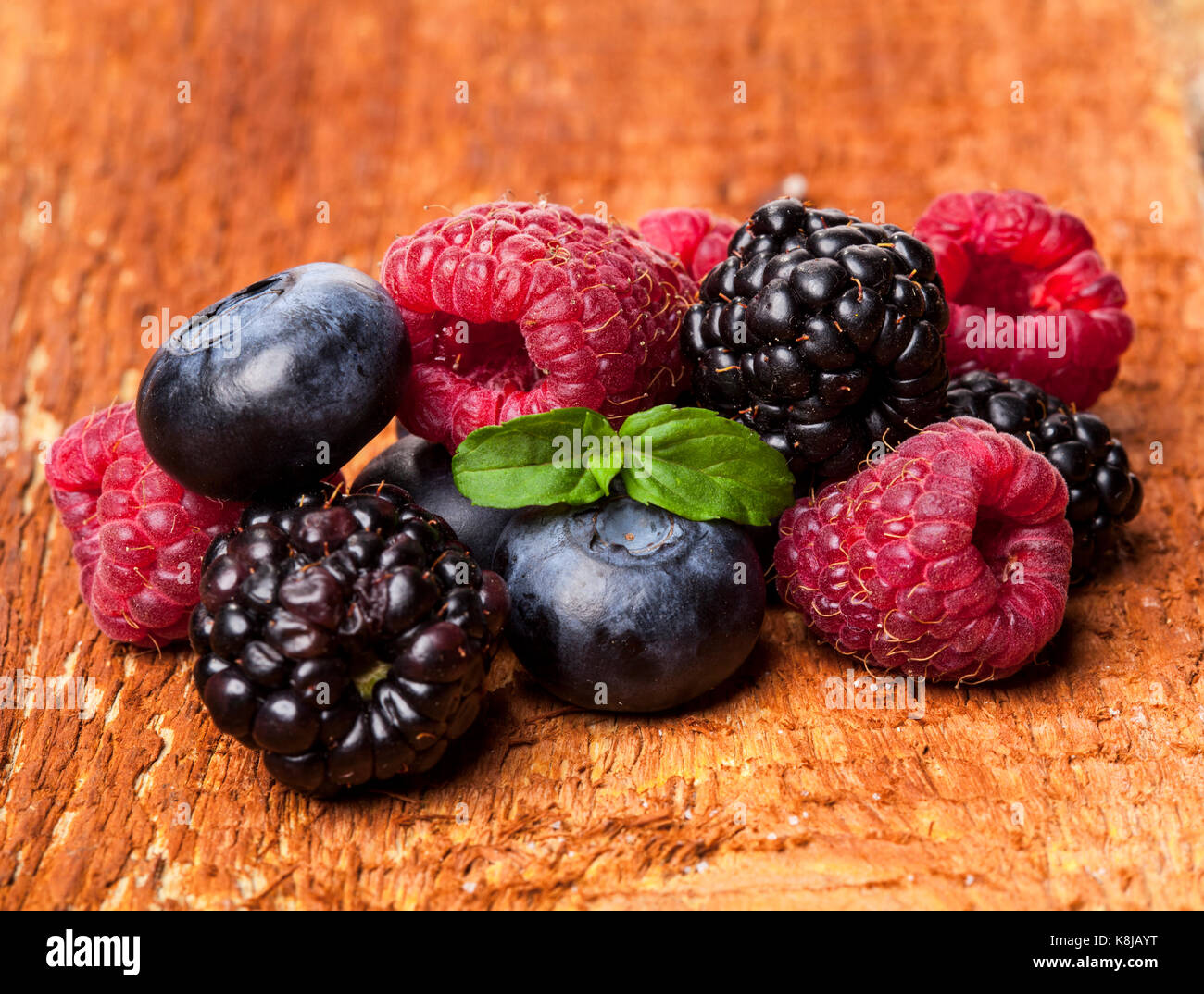 Ripe and sweet berries on wooden table Stock Photo - Alamy