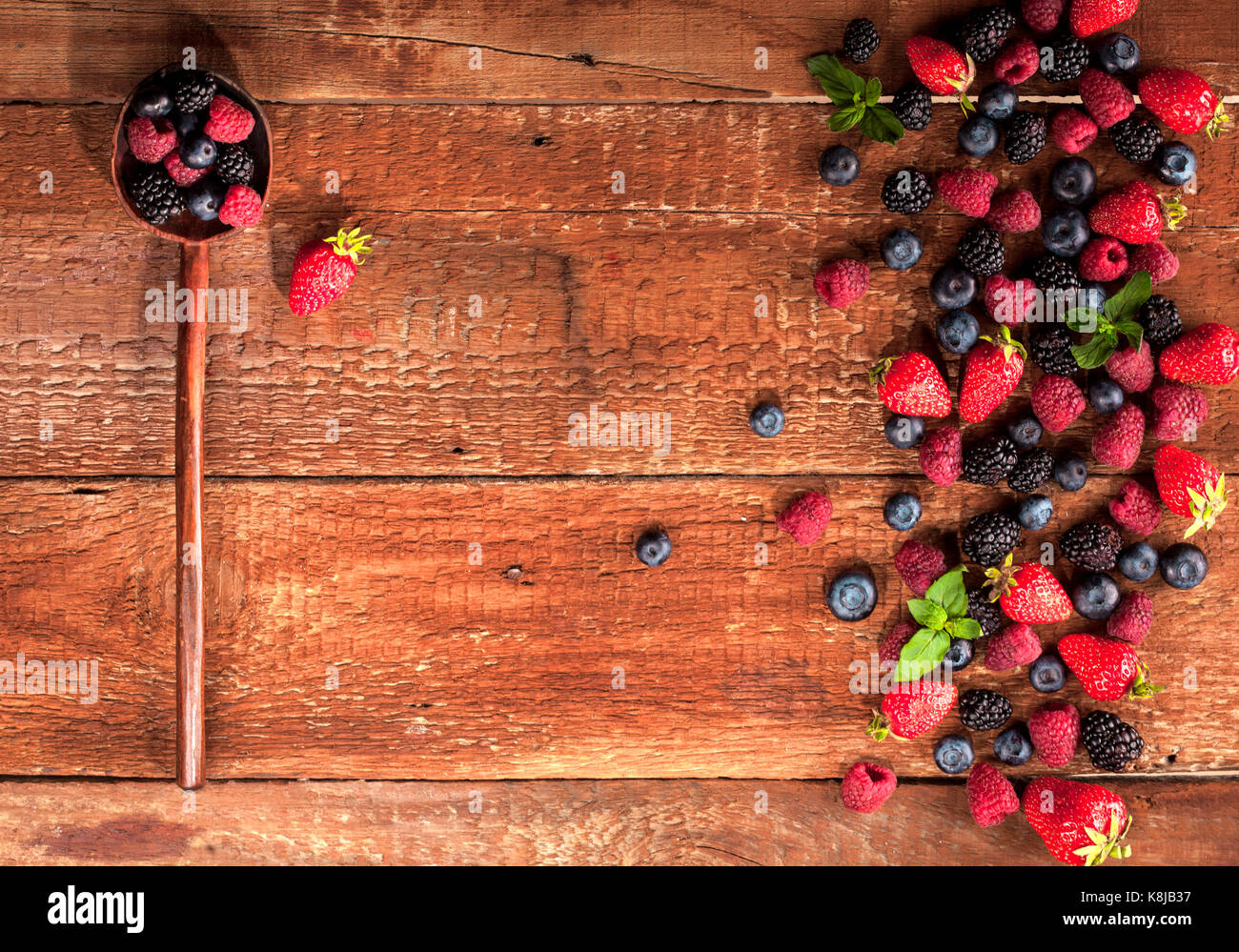 Ripe and sweet berries on wooden background with copy space Stock Photo ...
