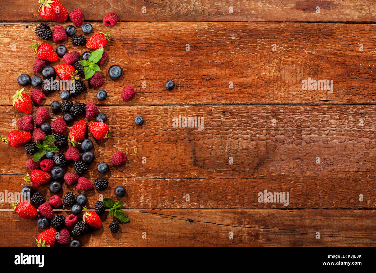 Ripe and sweet berries on wooden background with copy space Stock Photo ...