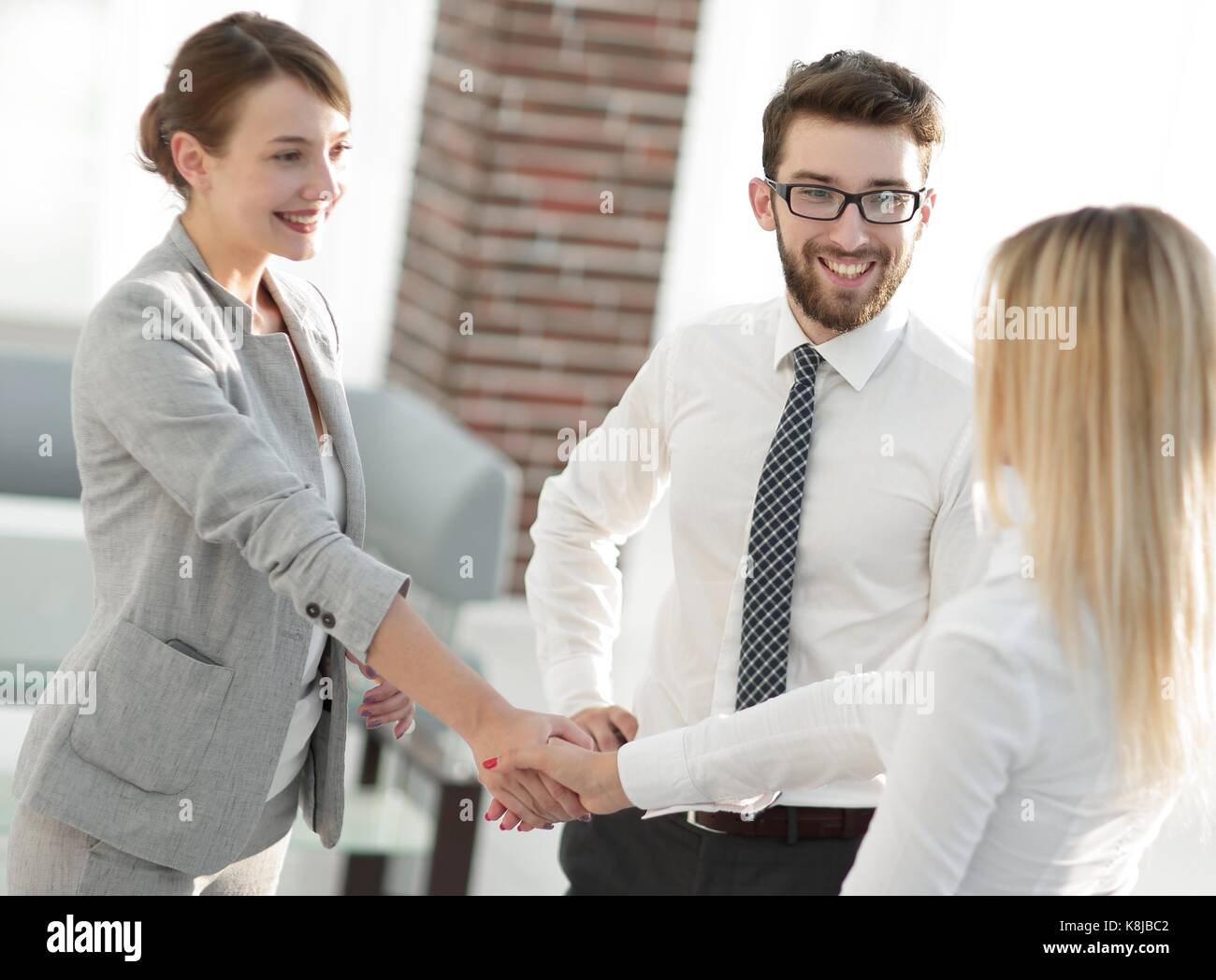 senior assistant looks at the handshake business partners Stock Photo ...