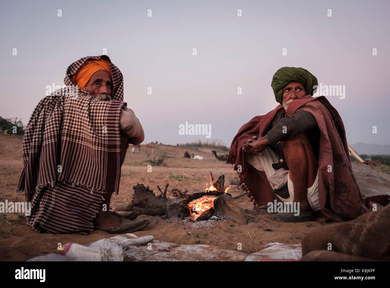 PUSHKAR, INDIA - CIRCA NOVEMBER 2016: Camel herders by a fire pit early ...