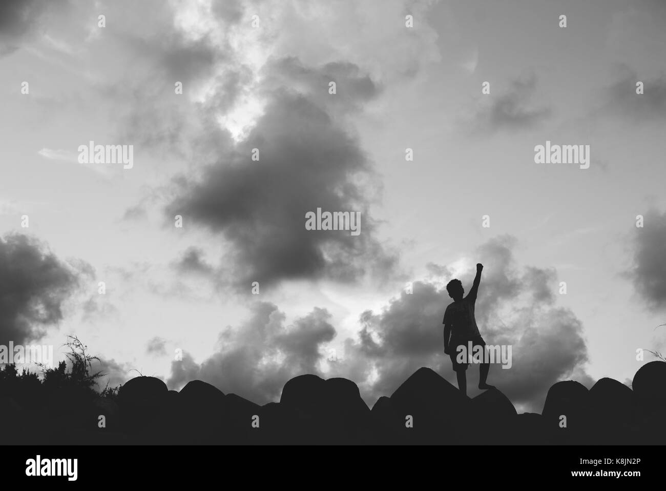 silhouette photo of a boy raised his hand.symbol of freedom and success ...
