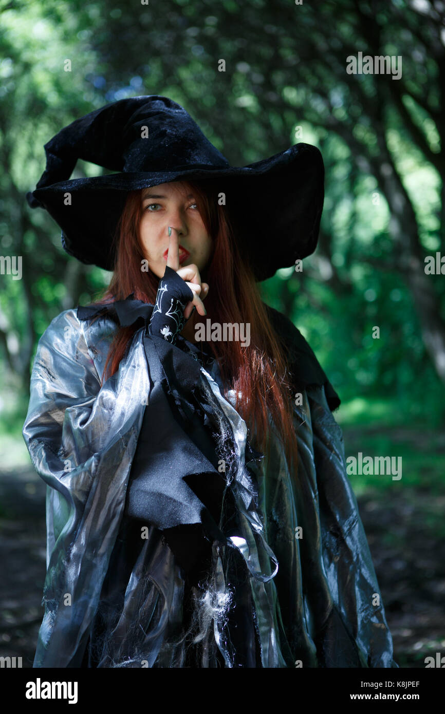 Portrait of witch with finger at mouth Stock Photo - Alamy