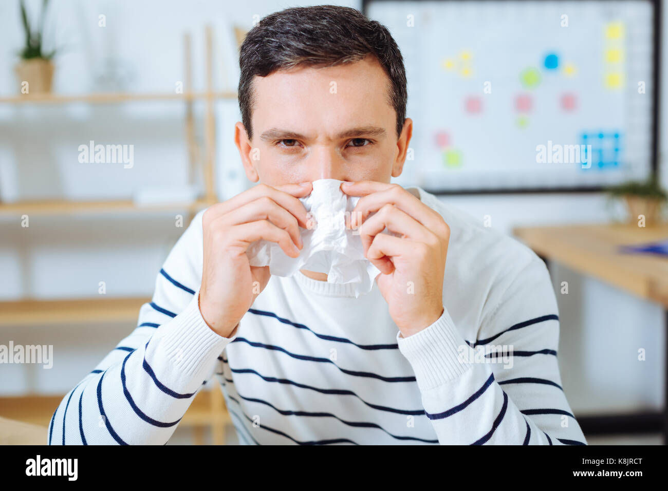 Angry brunette man blowing nose Stock Photo - Alamy