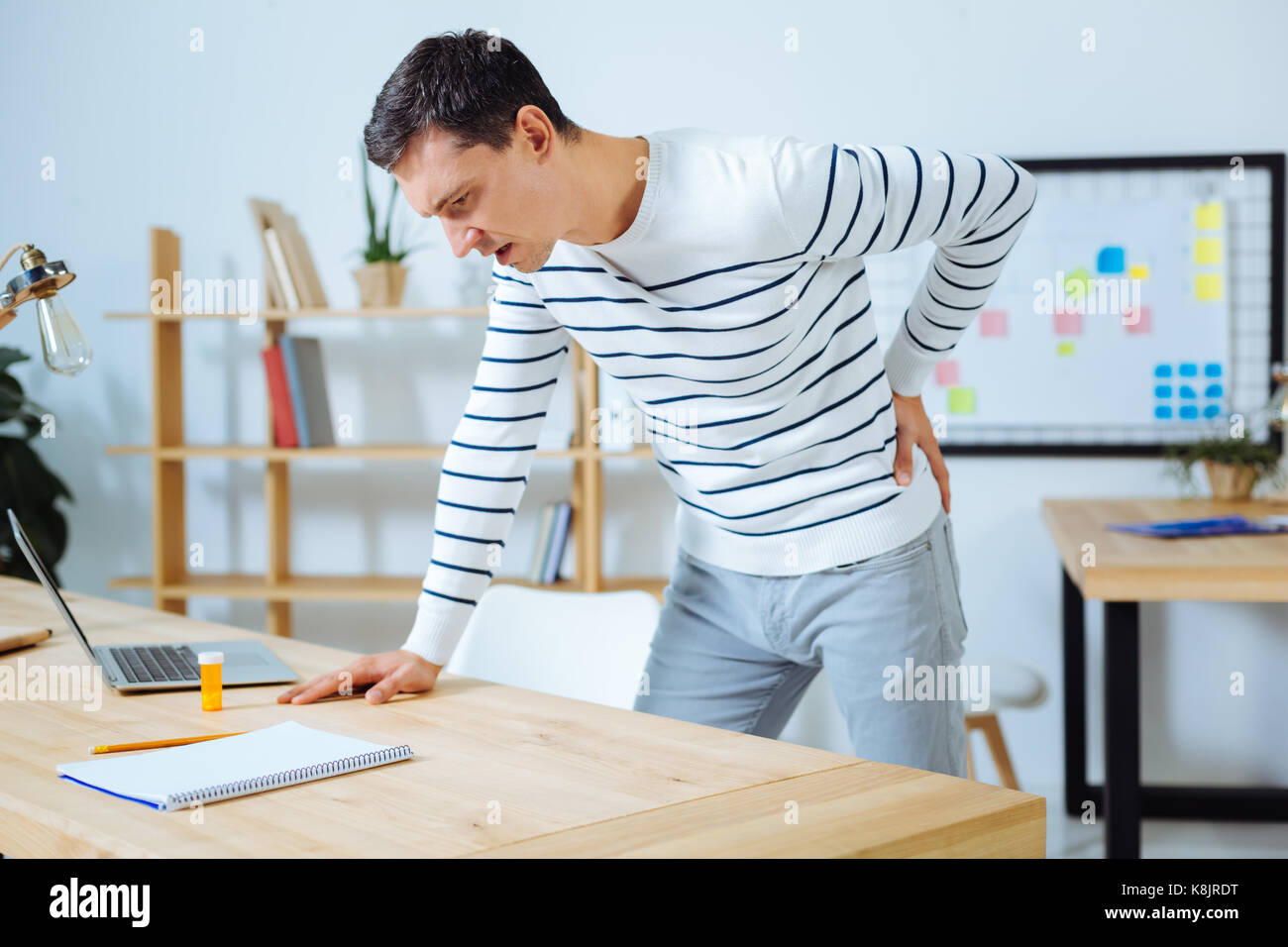 Angry male person keeping his back bent Stock Photo - Alamy
