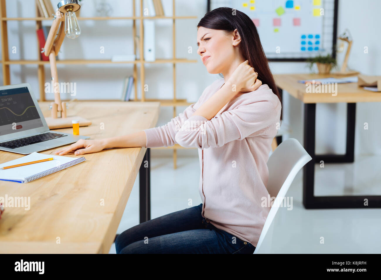 Upset female person touching her neck Stock Photo - Alamy