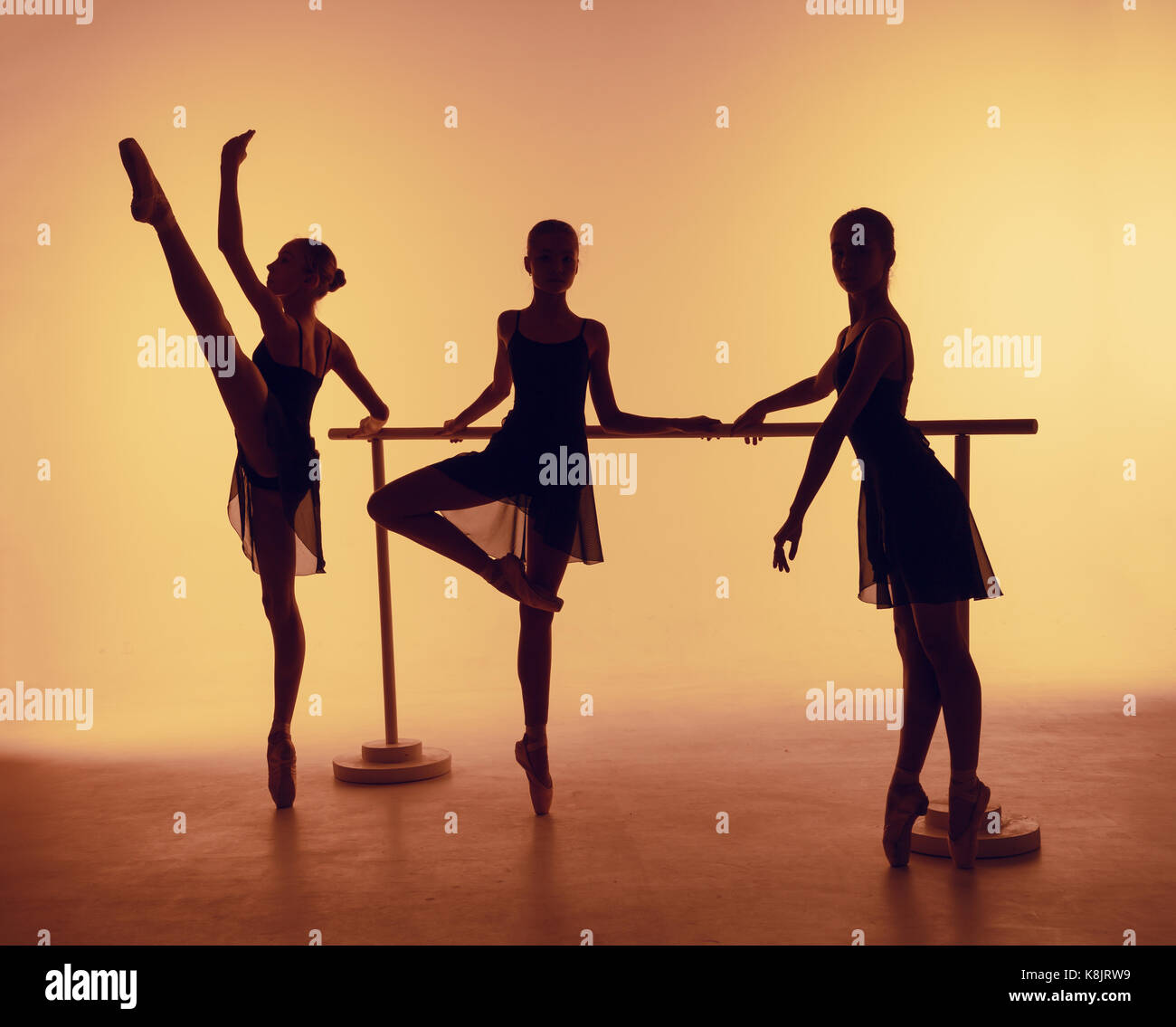 Composition from silhouettes of three young dancers in ballet poses on ...