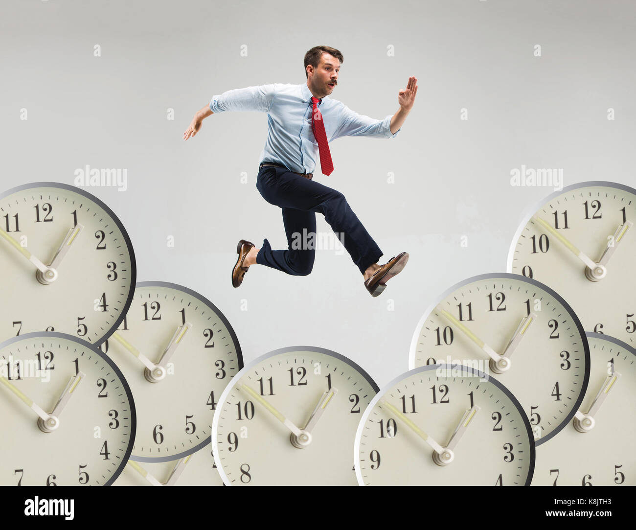 Businessman running over alarm clock Stock Photo - Alamy
