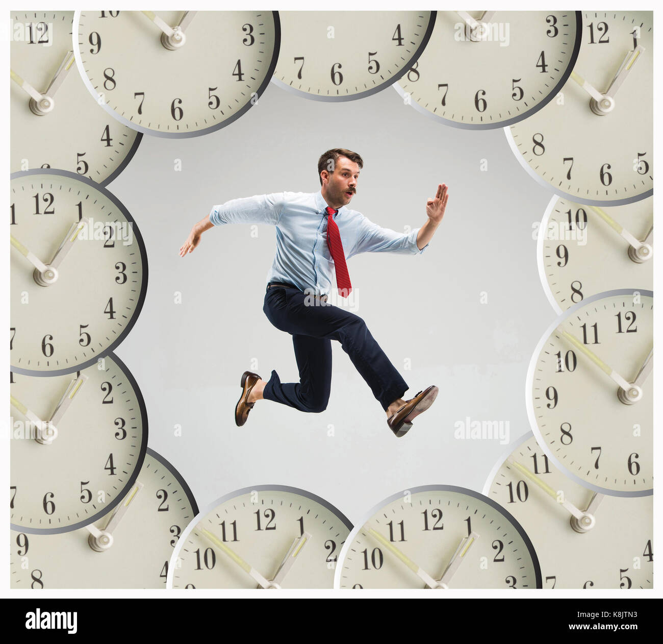 Businessman running over alarm clock Stock Photo - Alamy