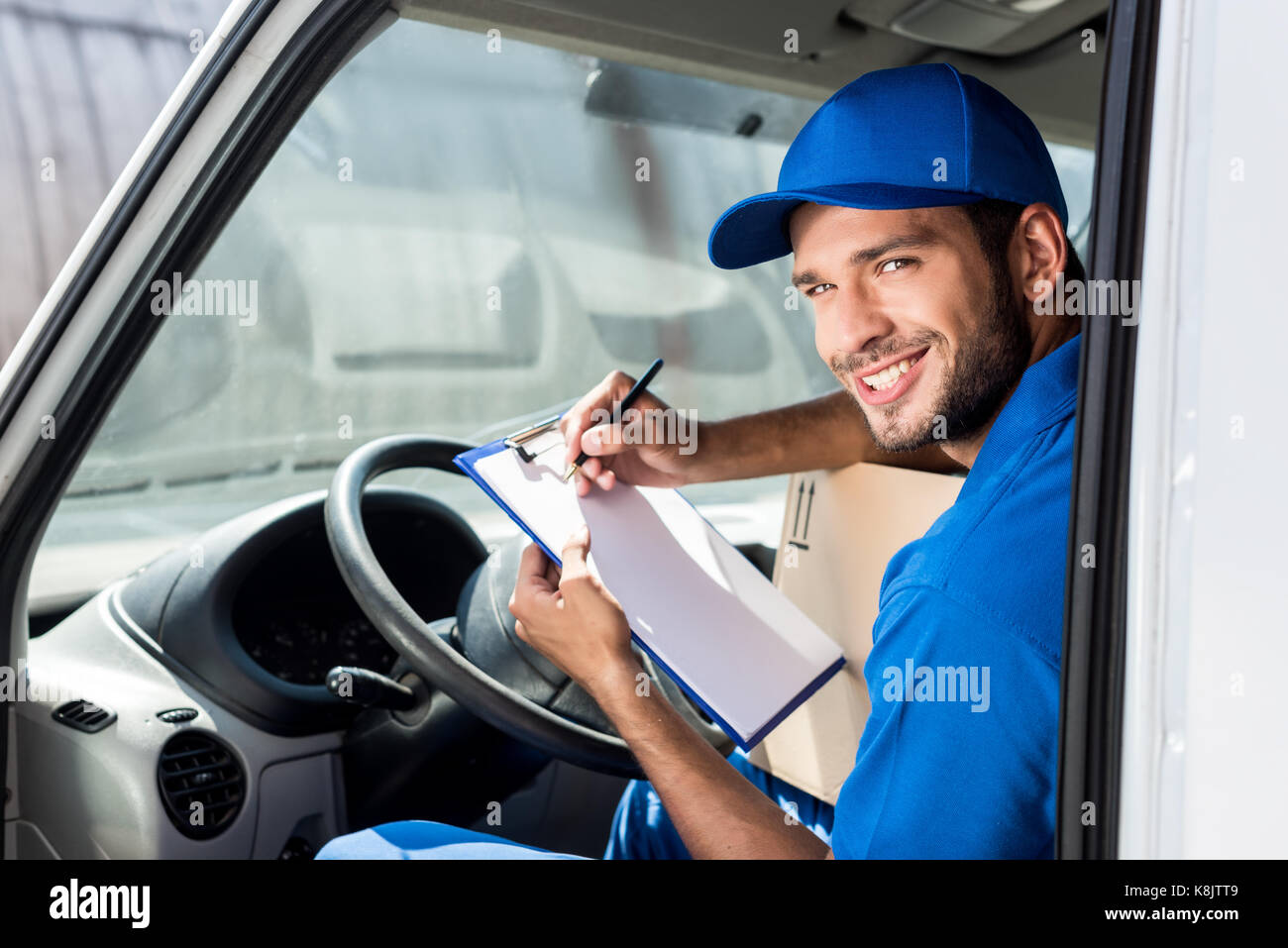 delivery man filling in documents Stock Photo - Alamy