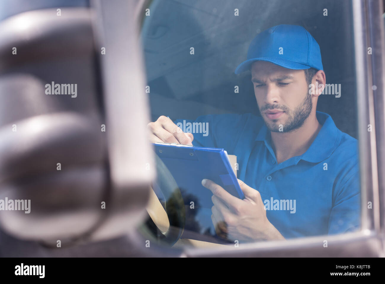 delivery man filling in documents Stock Photo - Alamy