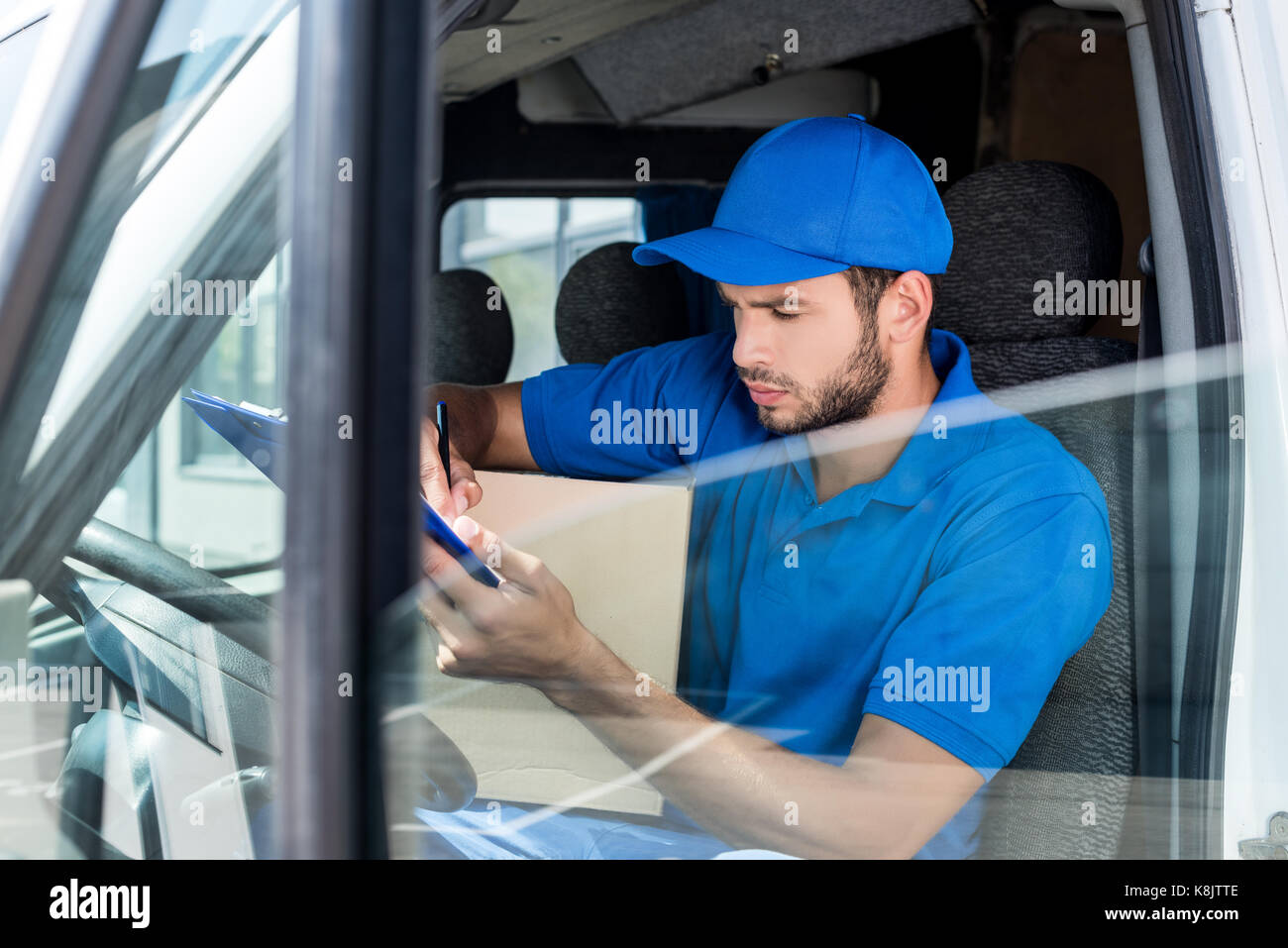 delivery man filling in documents Stock Photo - Alamy