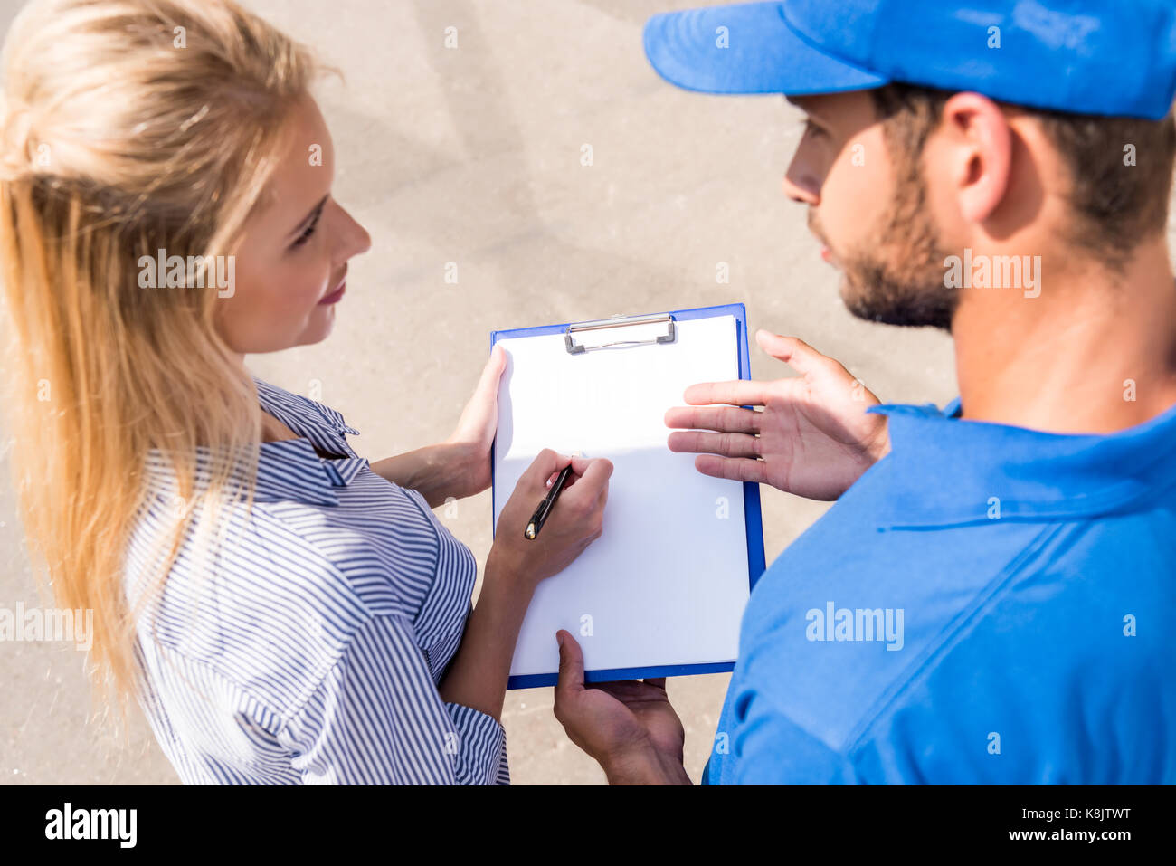 woman signing delivery document Stock Photo - Alamy