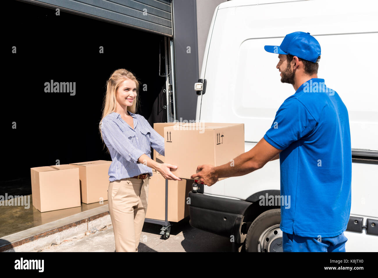 courier giving package to woman Stock Photo - Alamy
