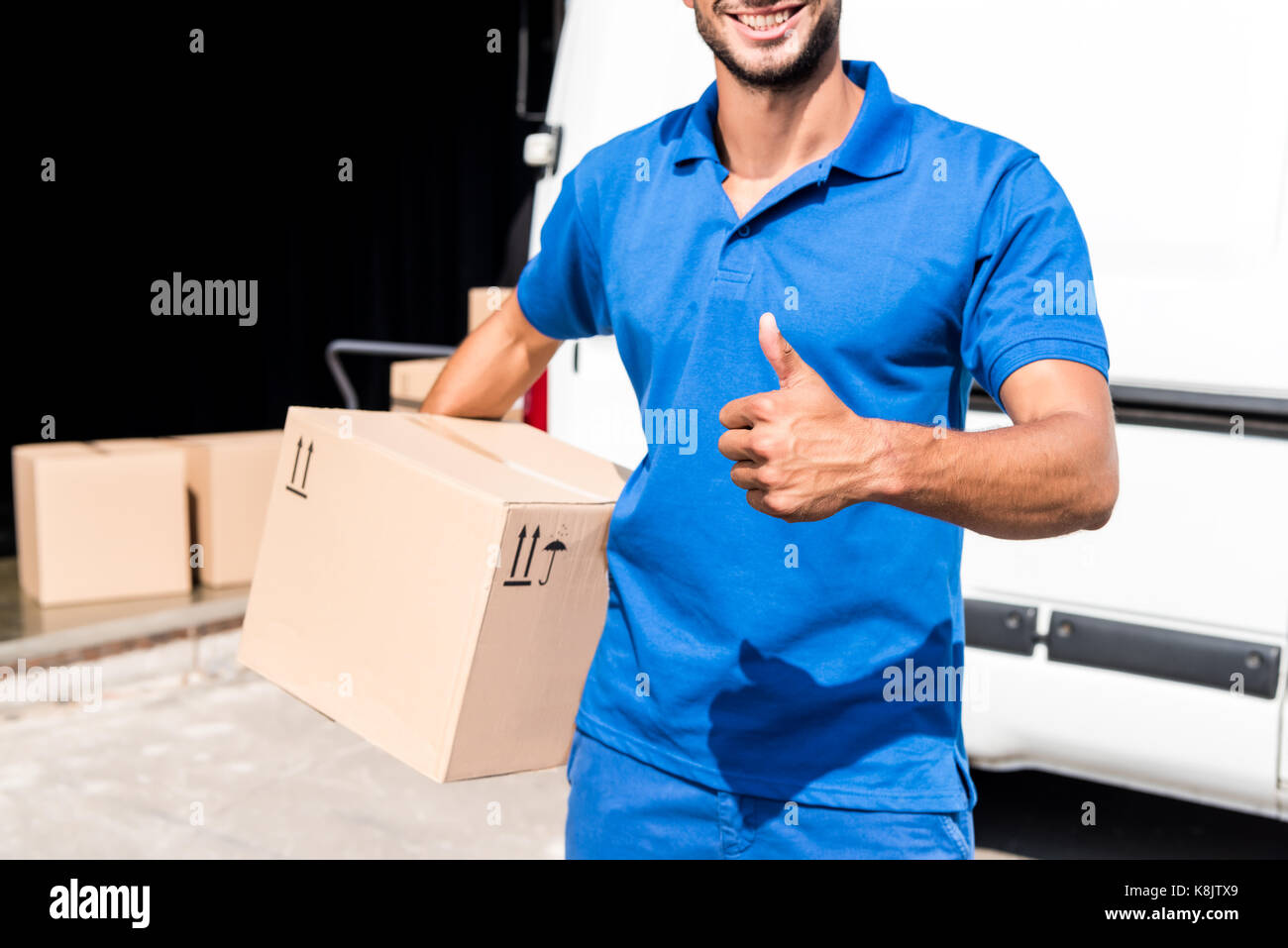 delivery man showing thumb up Stock Photo - Alamy