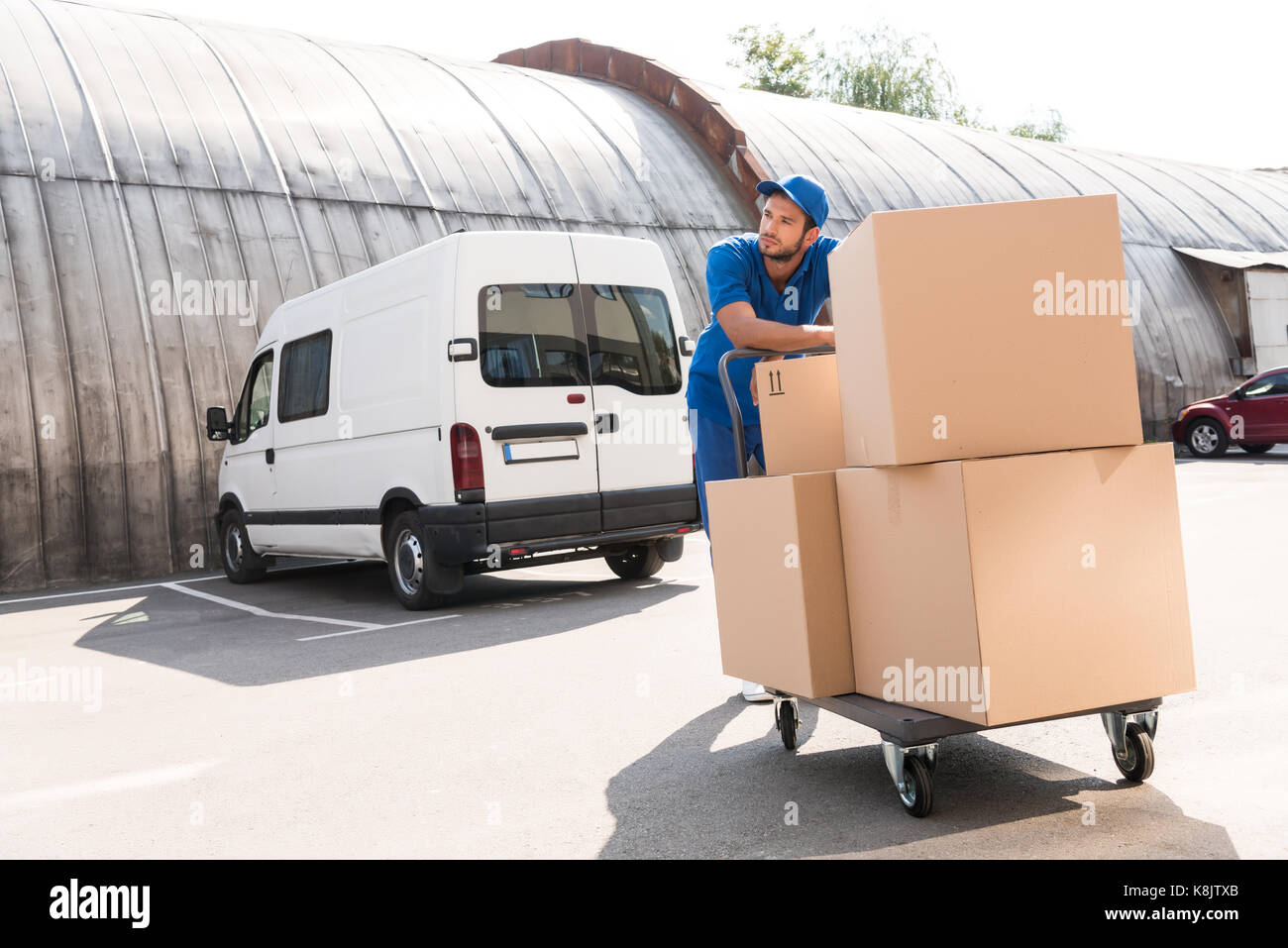 delivery man with boxes on cart Stock Photo - Alamy