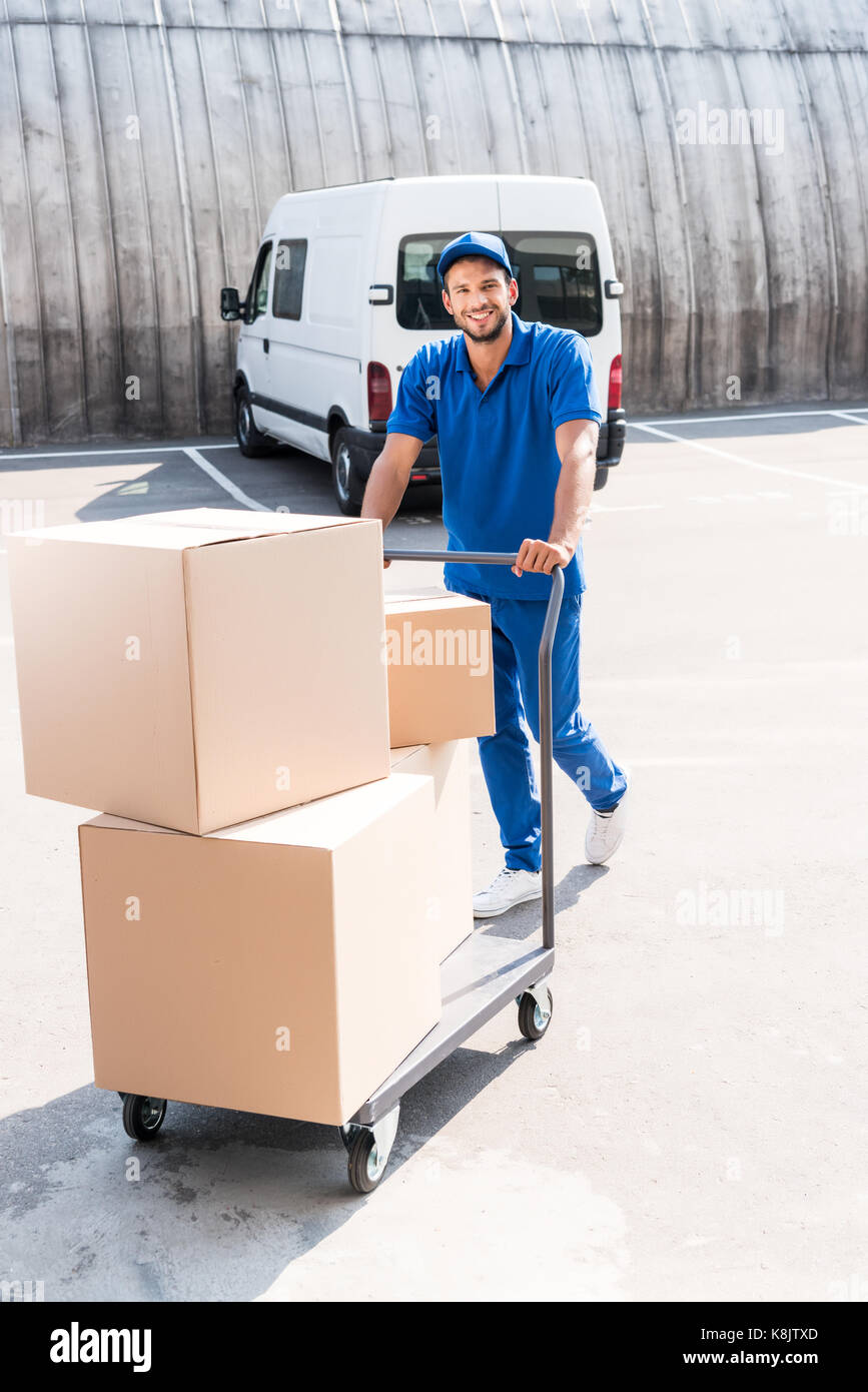 delivery man with boxes on cart Stock Photo - Alamy