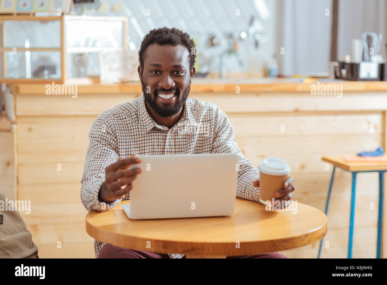 Smiling man adjusting angle of laptop screen Stock Photo - Alamy
