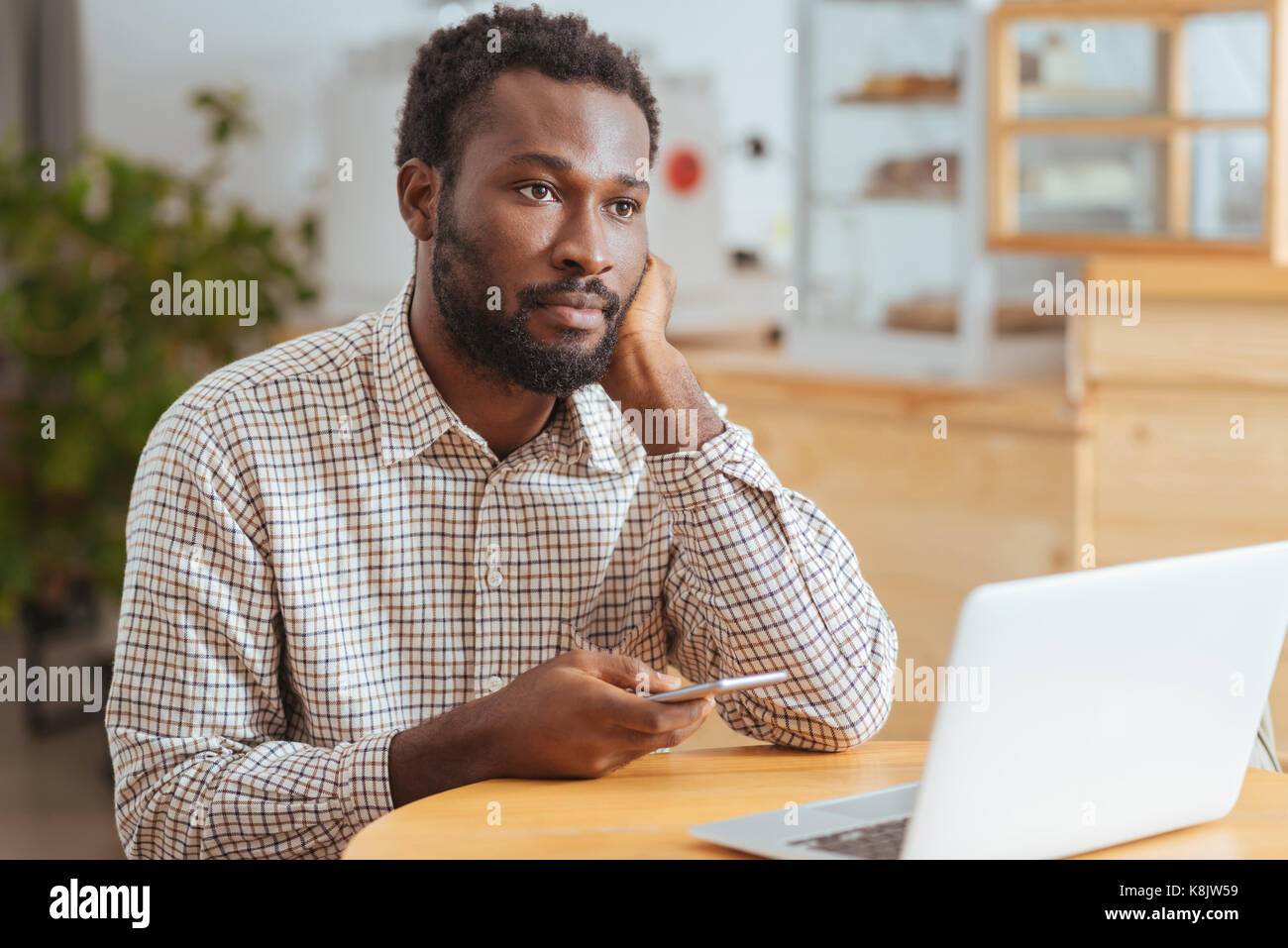 Young man thinking over message in cafe Stock Photo - Alamy
