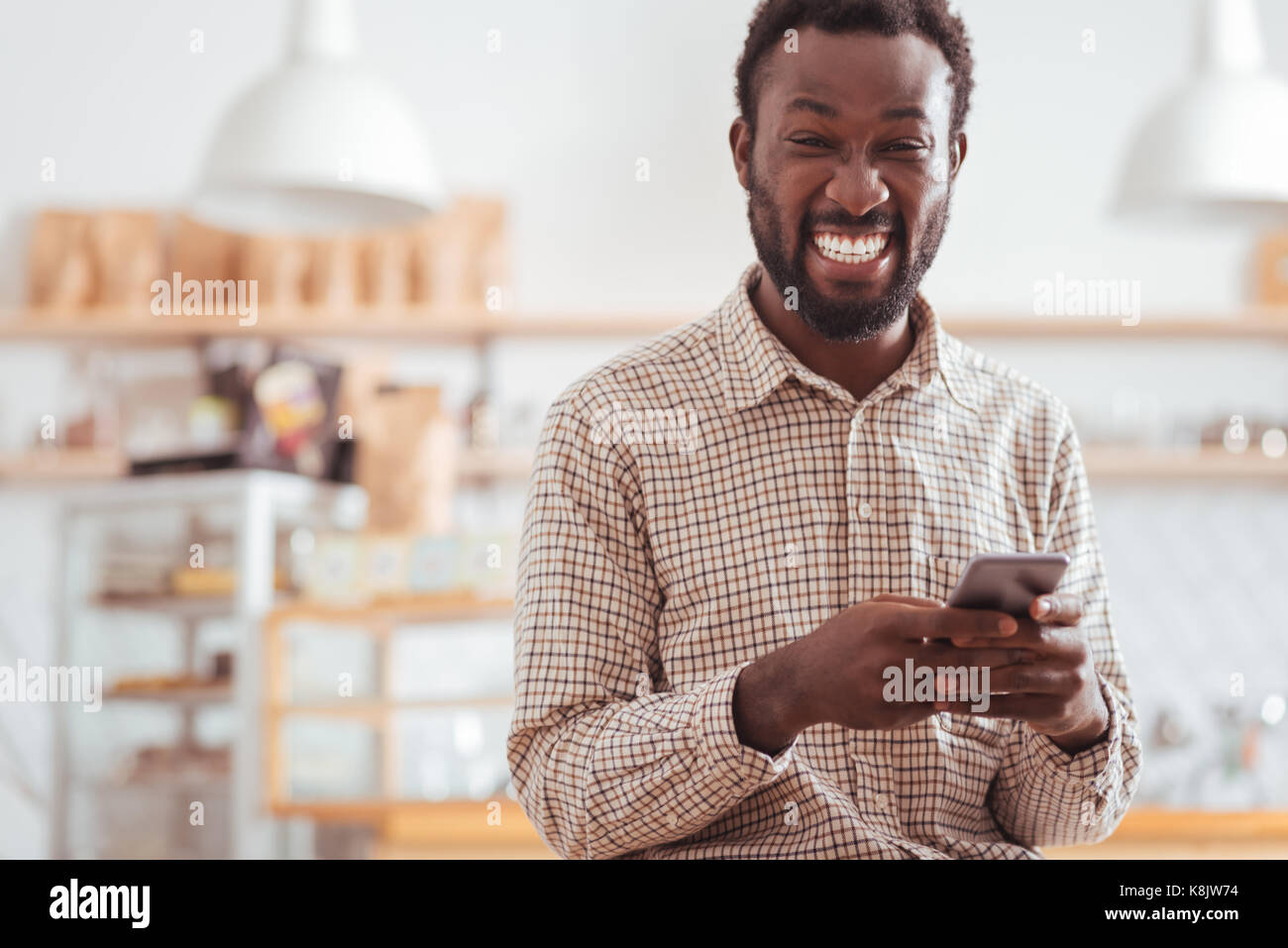 Overjoyed man laughing at his friends text messages Stock Photo - Alamy