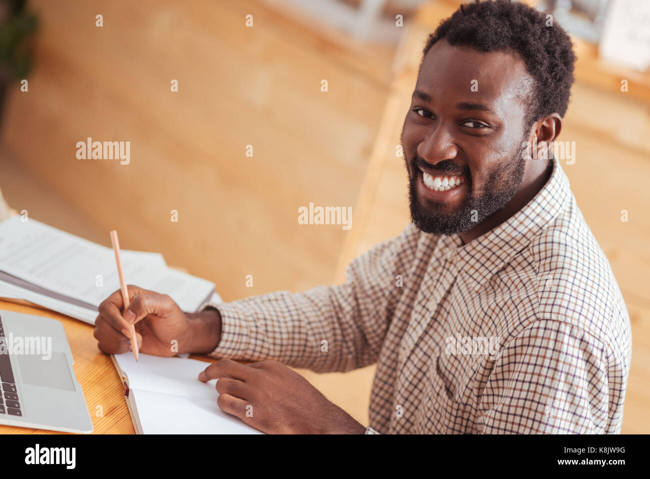 Happy man posing while writing in notebook Stock Photo - Alamy
