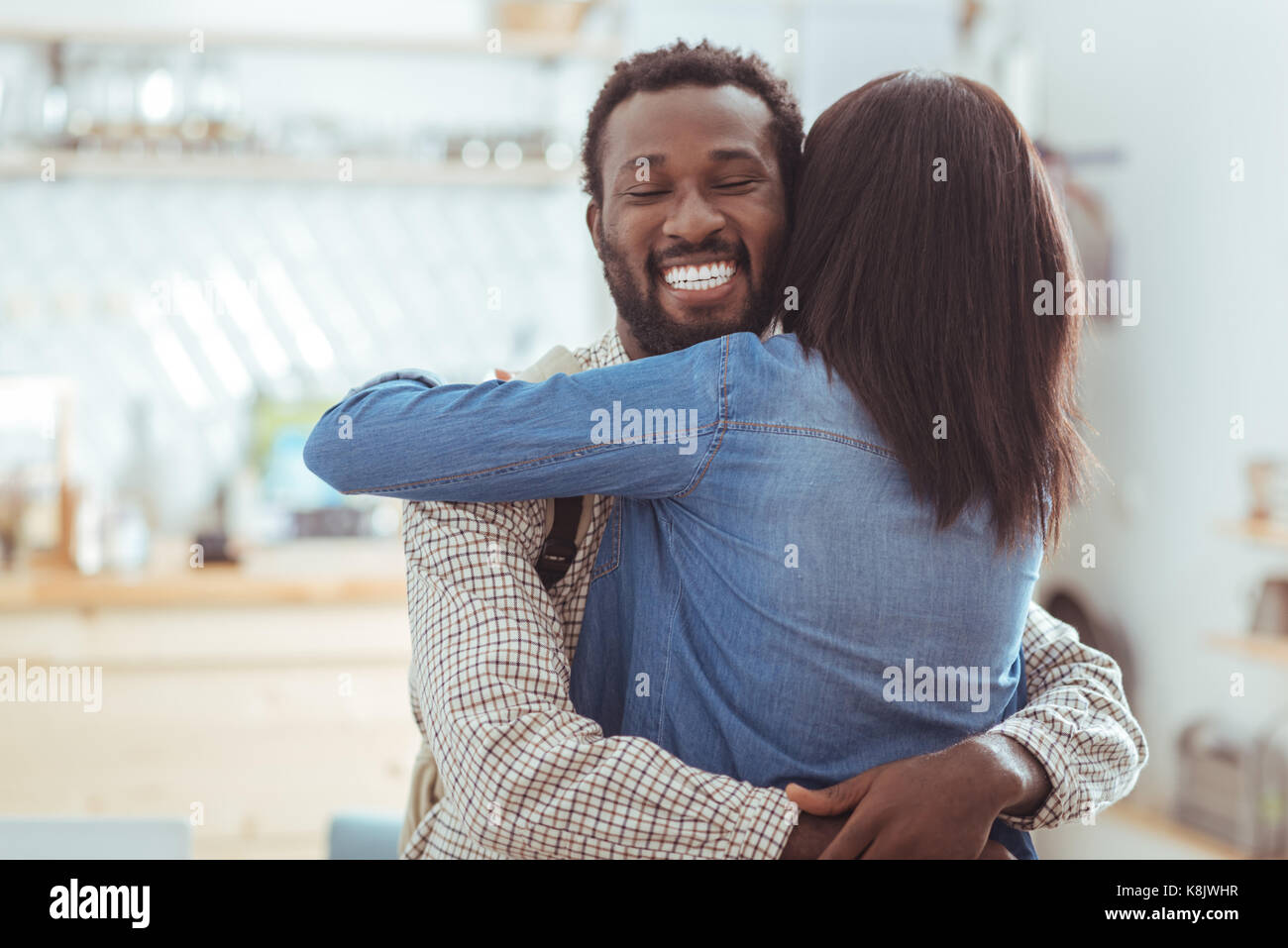 Happy man hugging his best friend in coffeehouse Stock Photo - Alamy