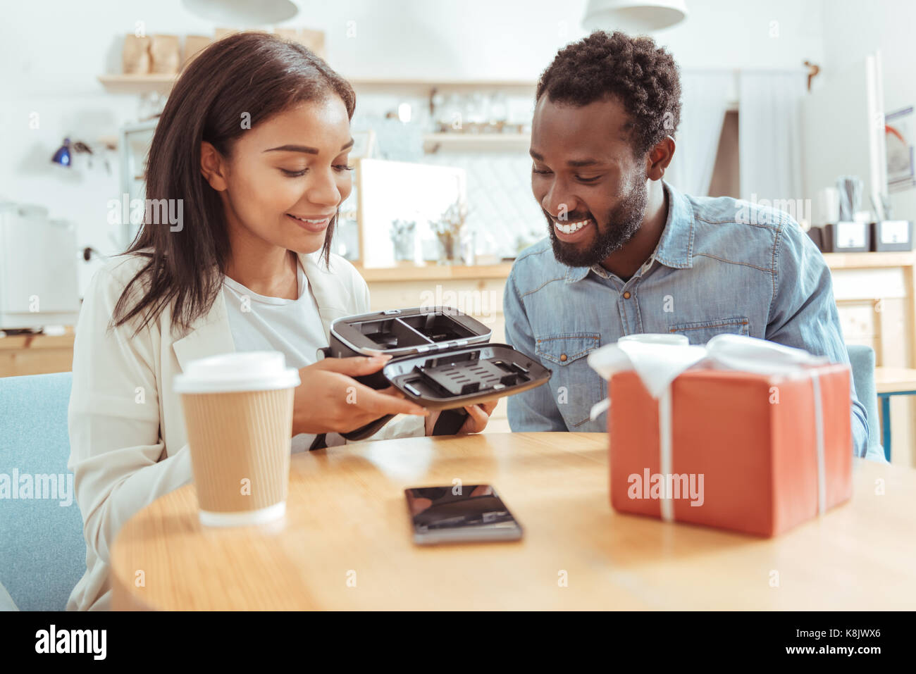 Gorgeous woman looking inside VR headset with her friend Stock Photo ...