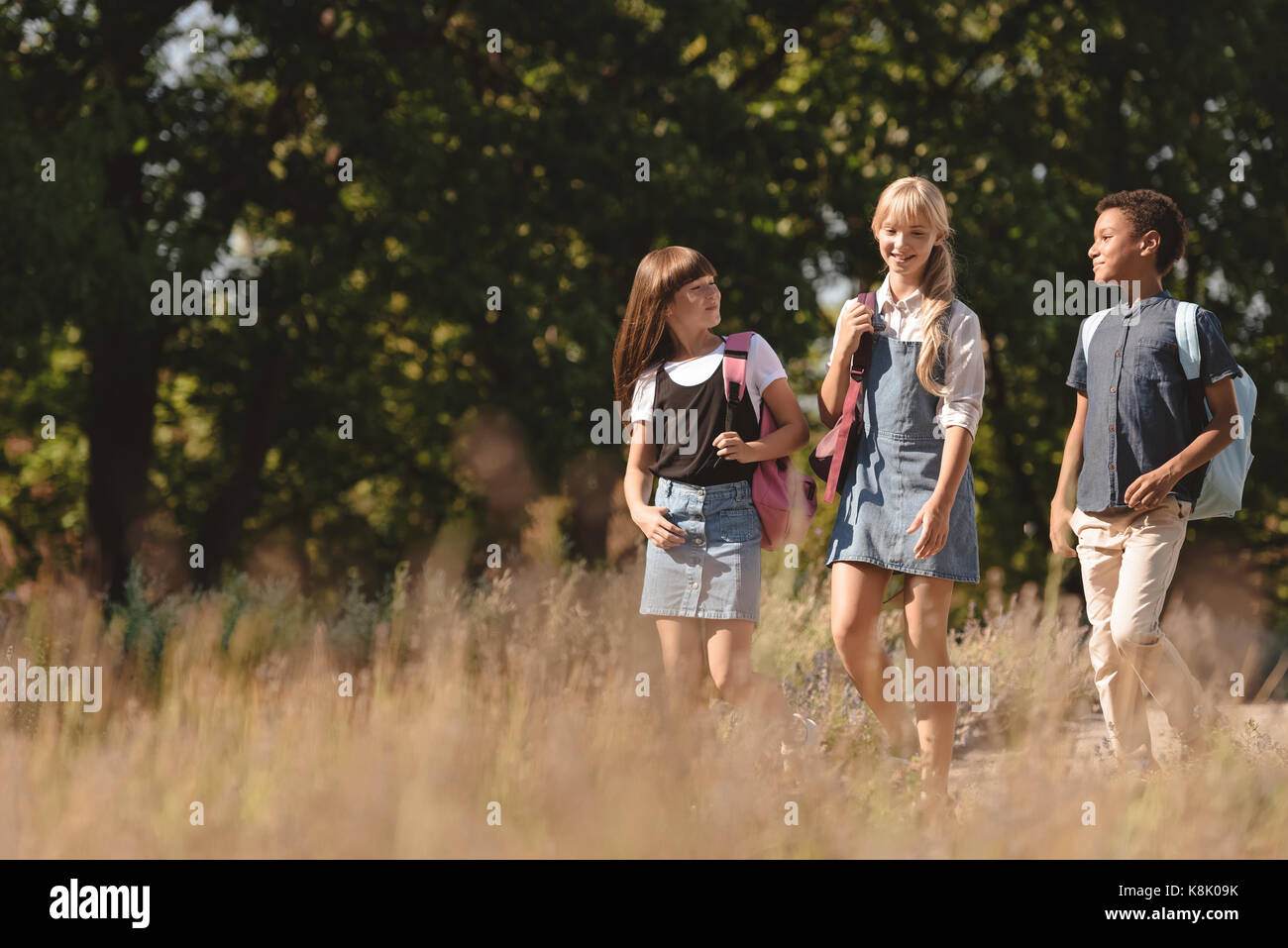 multiethnic teens walking in park Stock Photo - Alamy