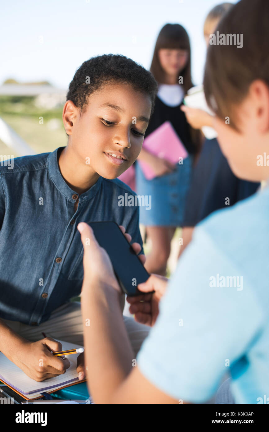multiethnic boys using smartphone Stock Photo - Alamy