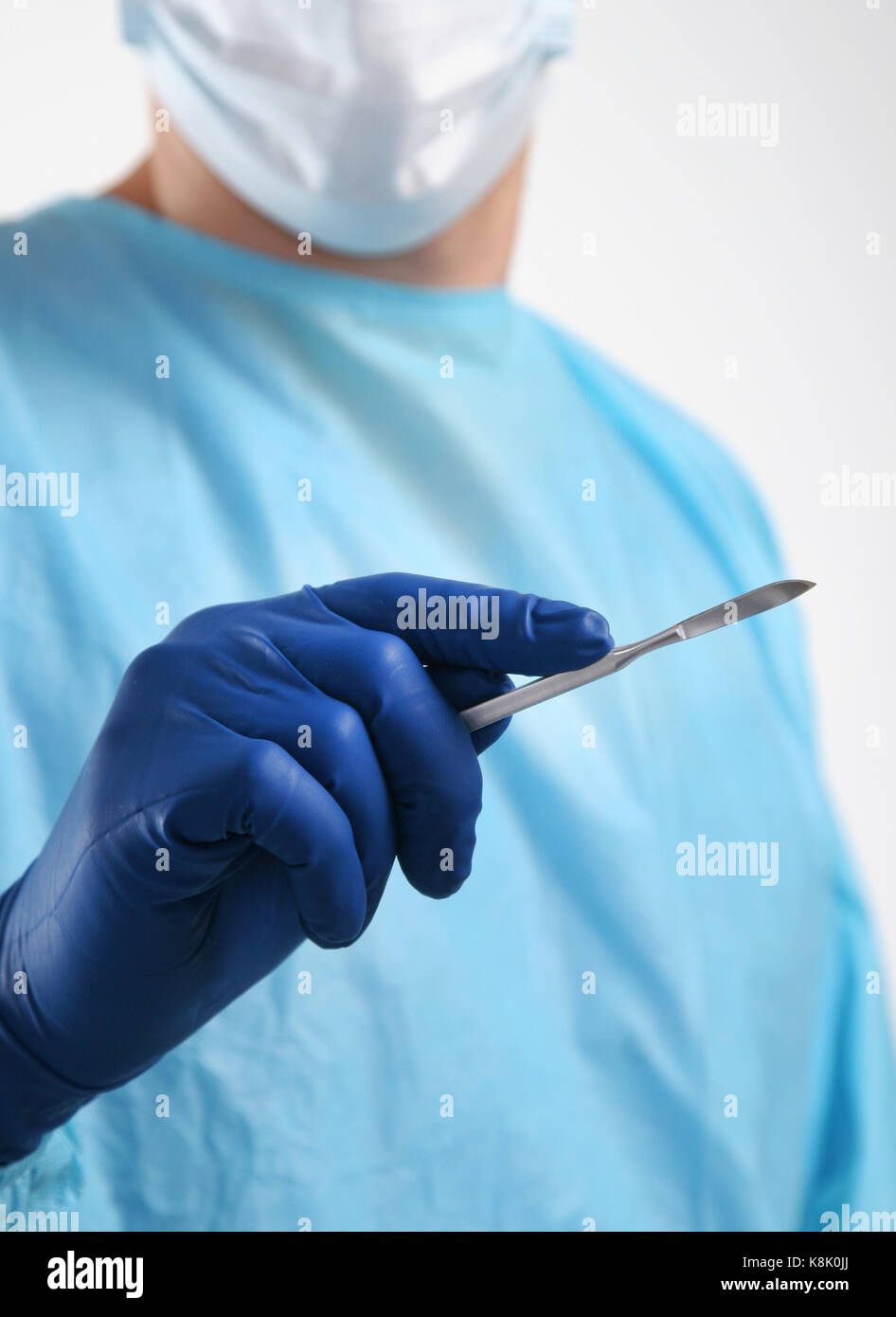 Man surgeon holds a scalpel Stock Photo - Alamy