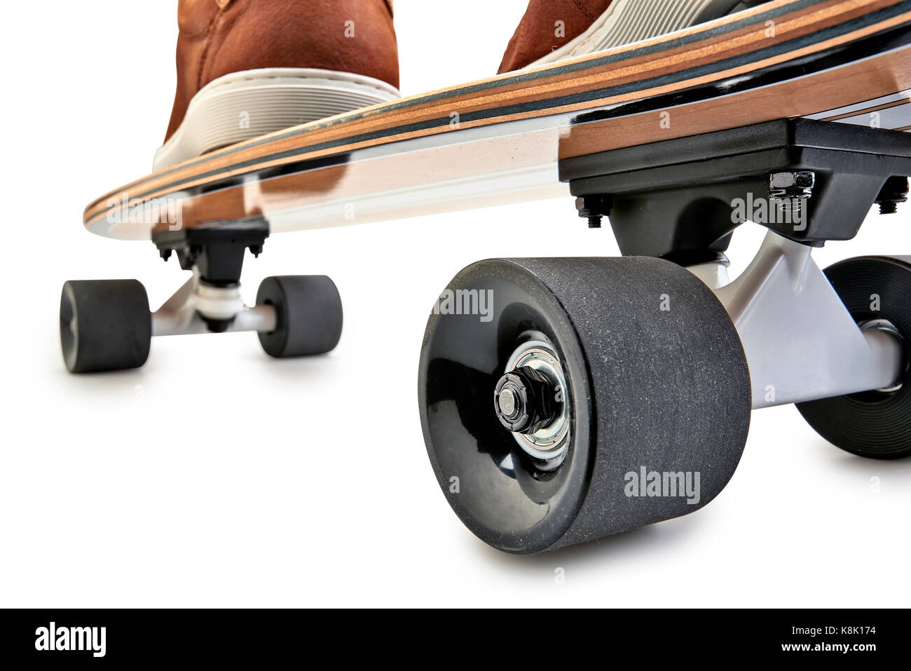 Dynamic rear view of a Black and wooden skate board and brown leathers ...