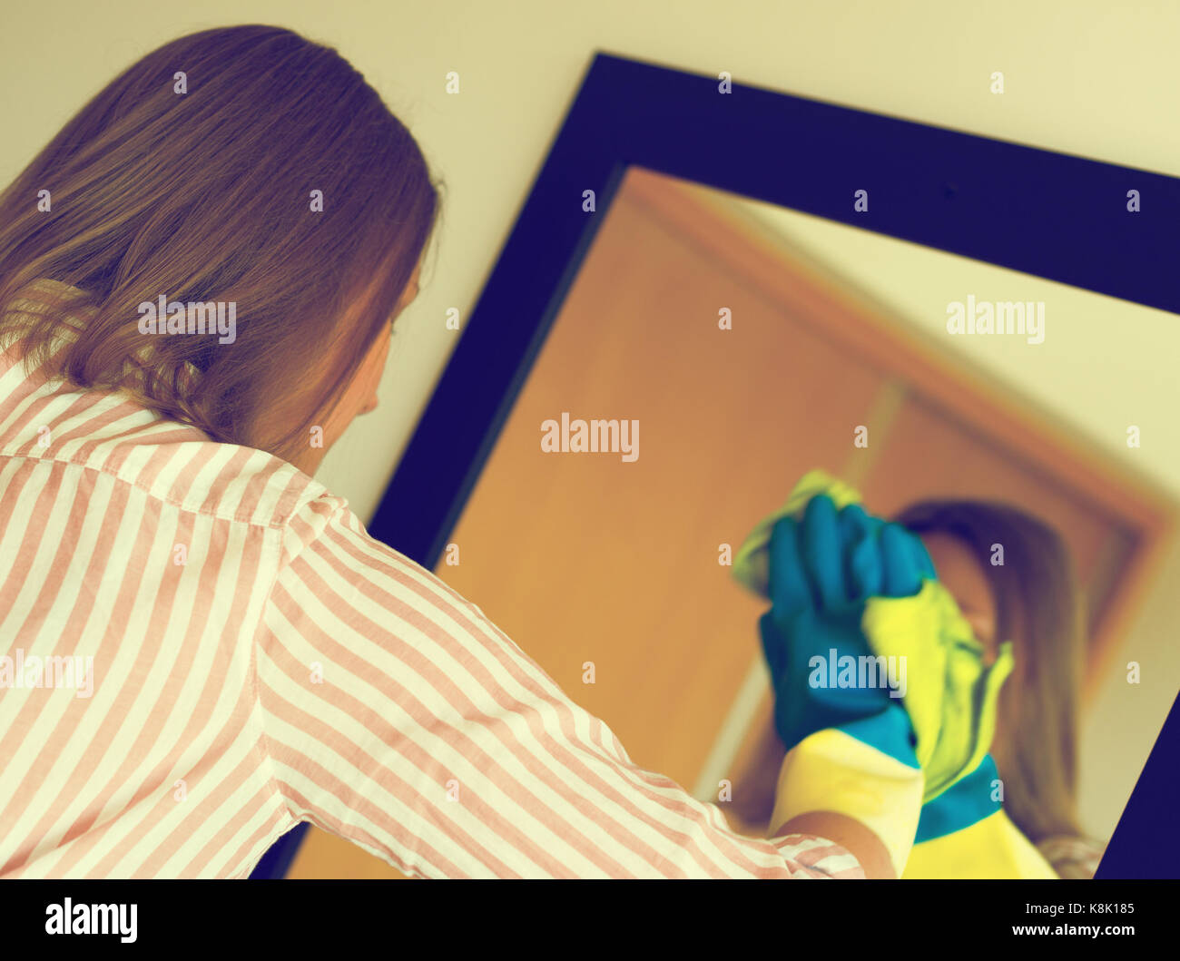House cleaning. Woman is wiping mirror in the room Stock Photo - Alamy