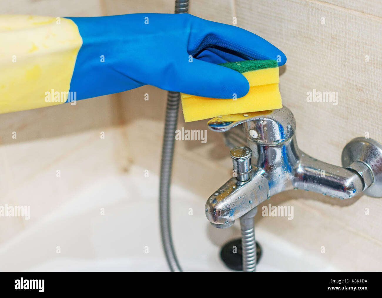 House cleaning. Woman cleaning tap in bathroom Stock Photo - Alamy