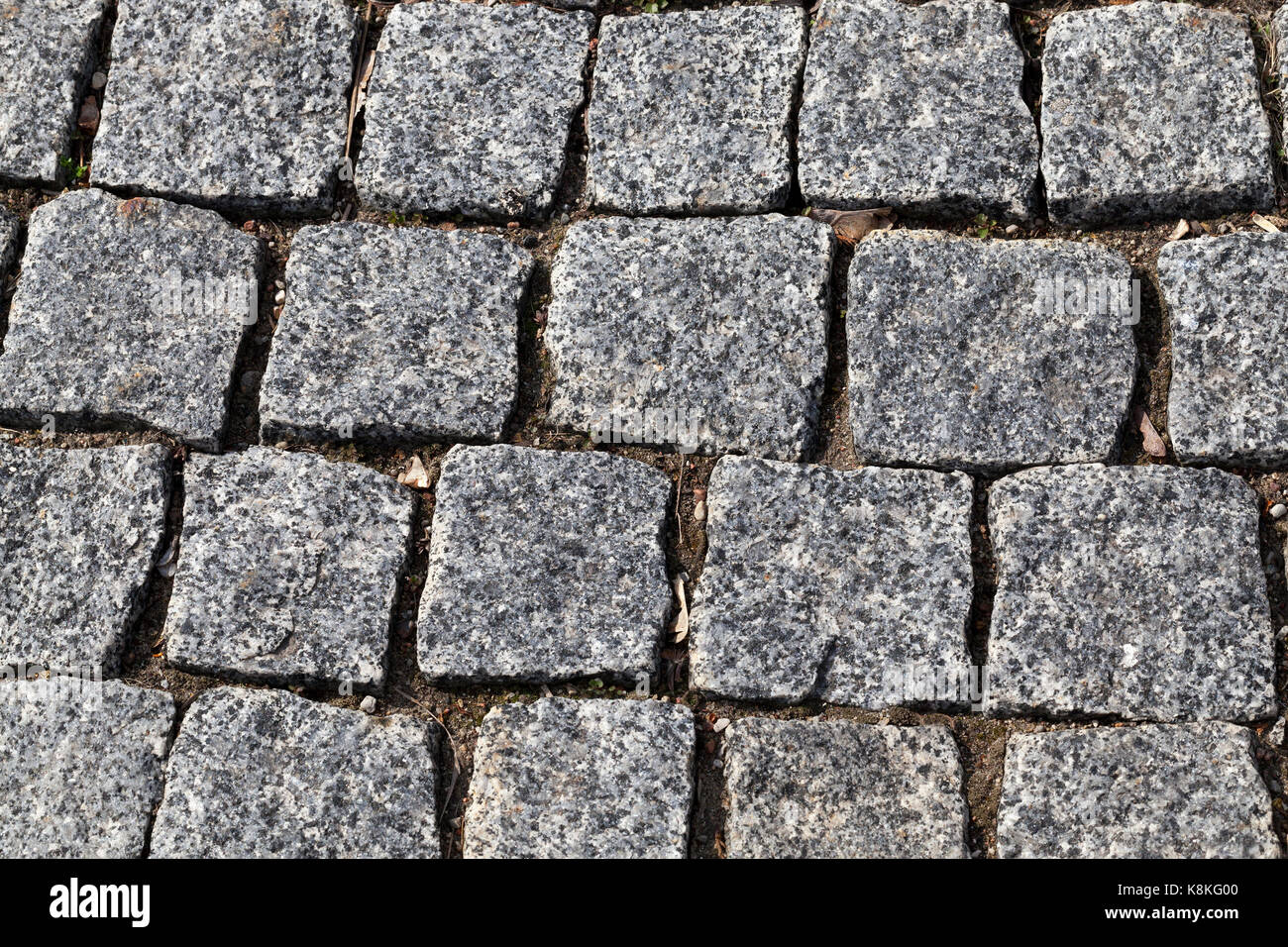 A close-up photograph of a part of the road made of small cobblestones ...