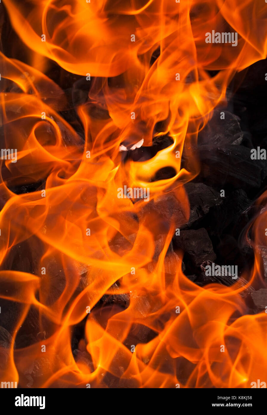 background of an orange beautiful flame in a fire with wooden logs. In ...